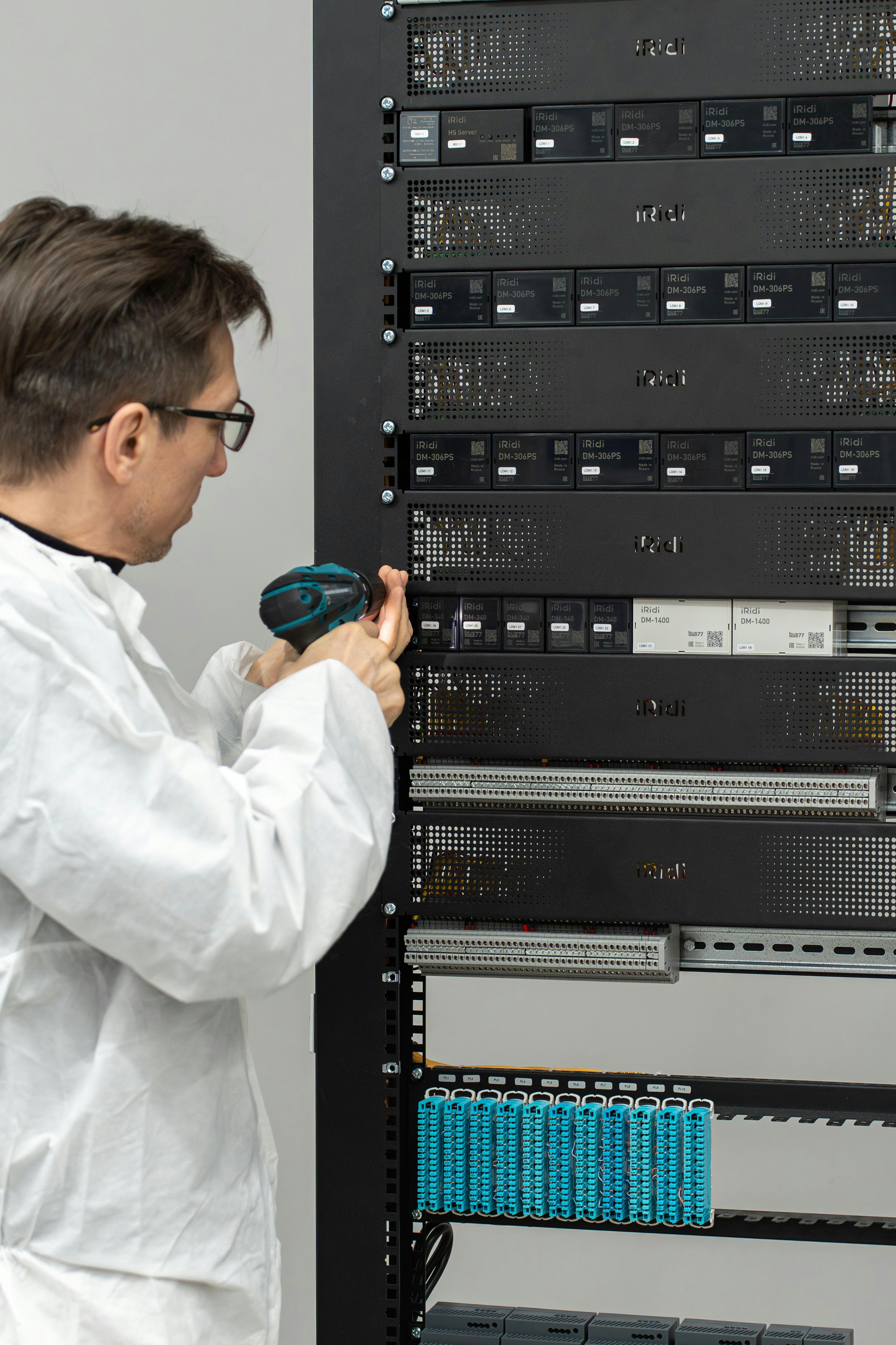 Engineer at Work: The Tech Rack and the Drill in a Quiet Server Room