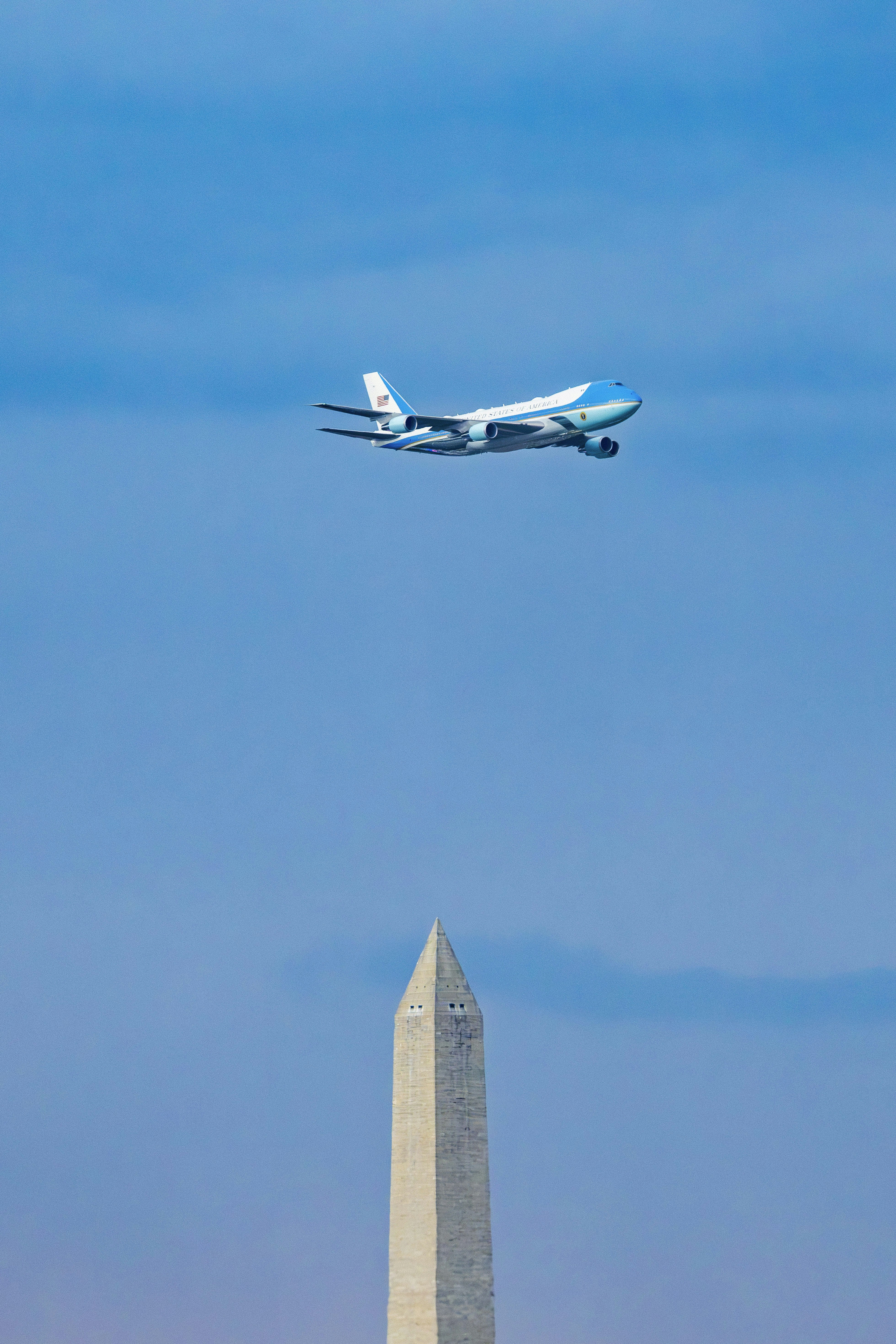 Jet Above the Obelisk: Flight Path Over a Blue Sky