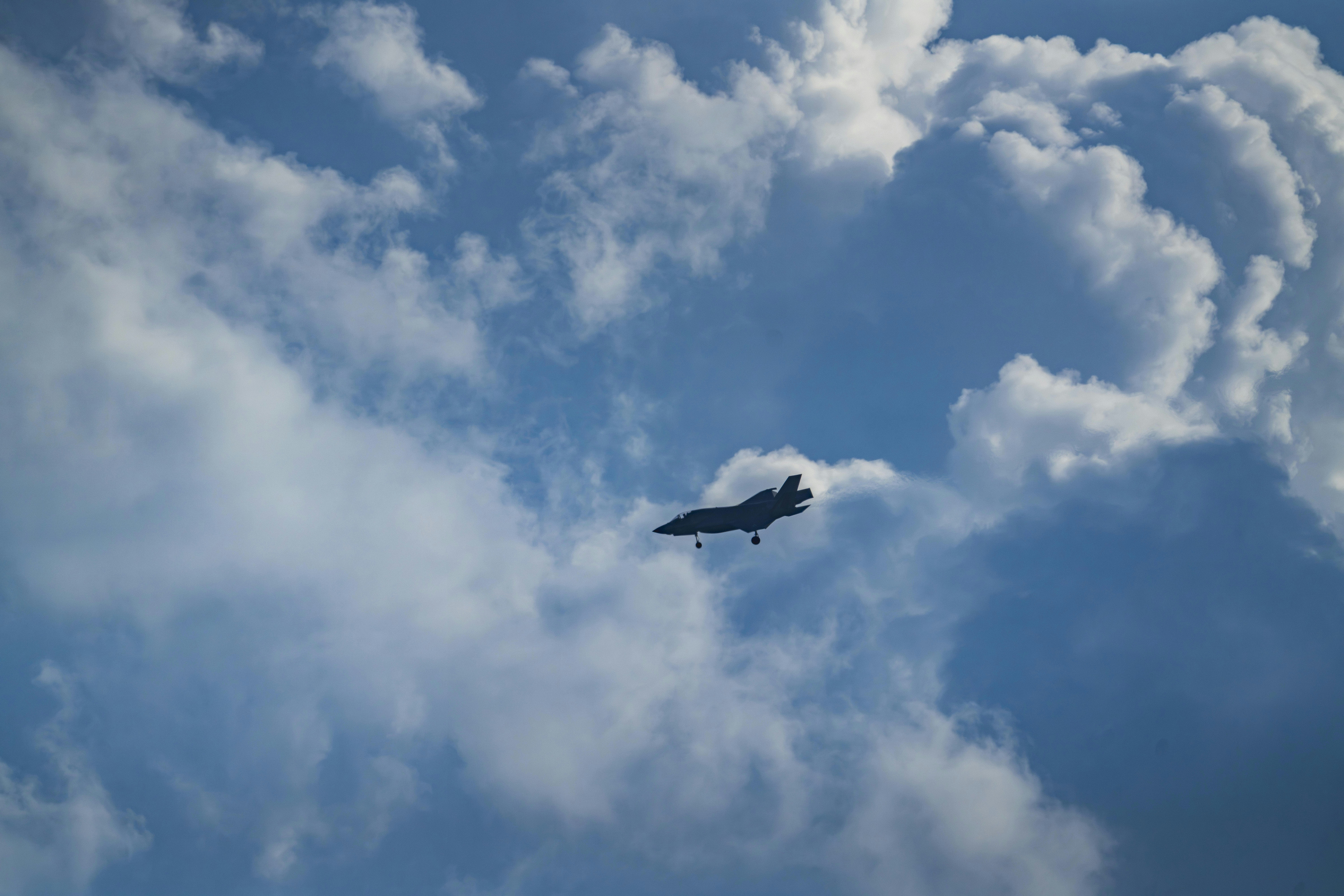 Mid‑Air Silhouette: Jet Tracing a Quiet Blue Horizon