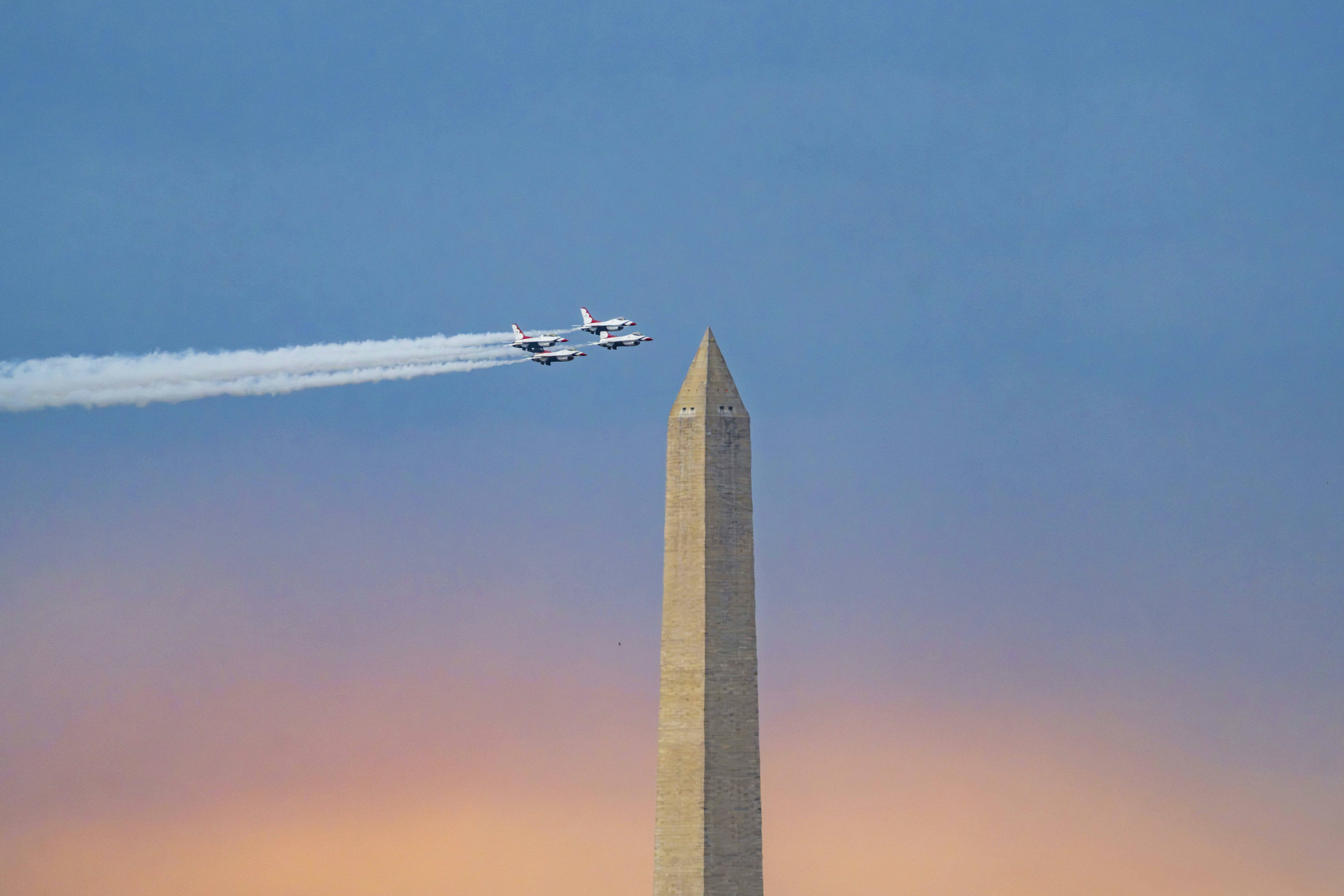 Skyward Duo: Jets Crossing the Painted Sky Over the Obelisk