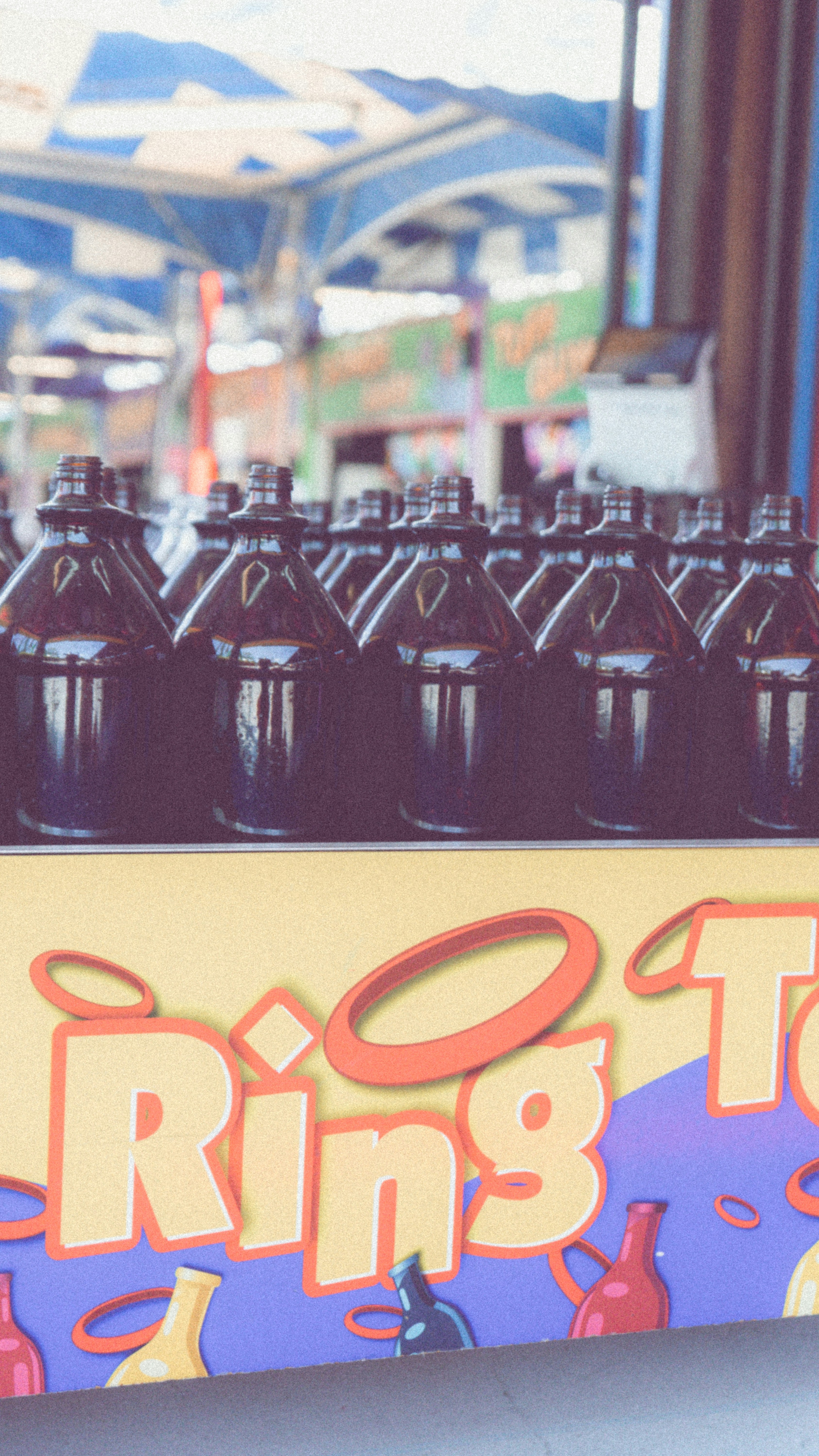 Row of dark bottles beneath a colorful storefront sign