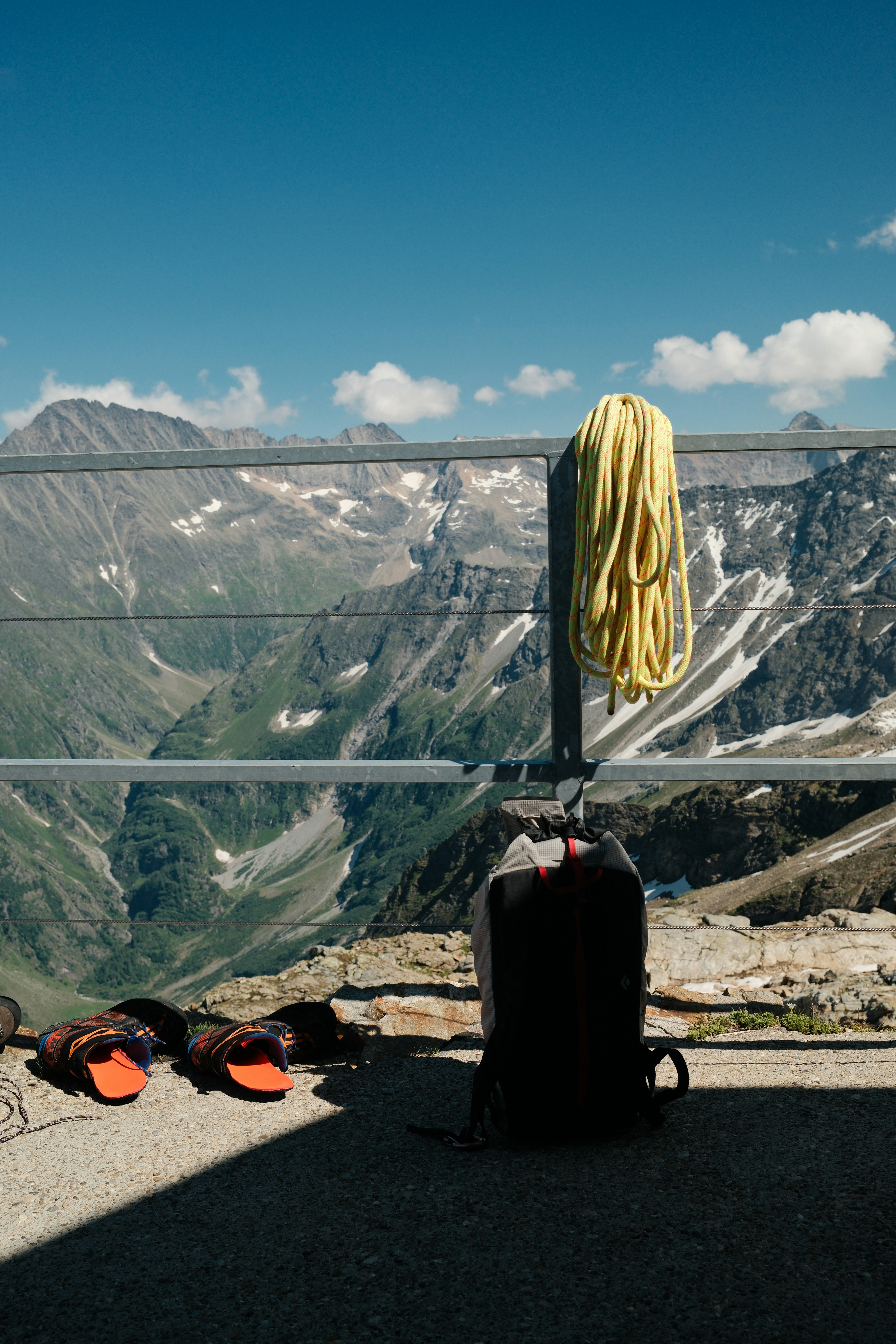 Lone hiking base at a mountain pass with gear by a railing