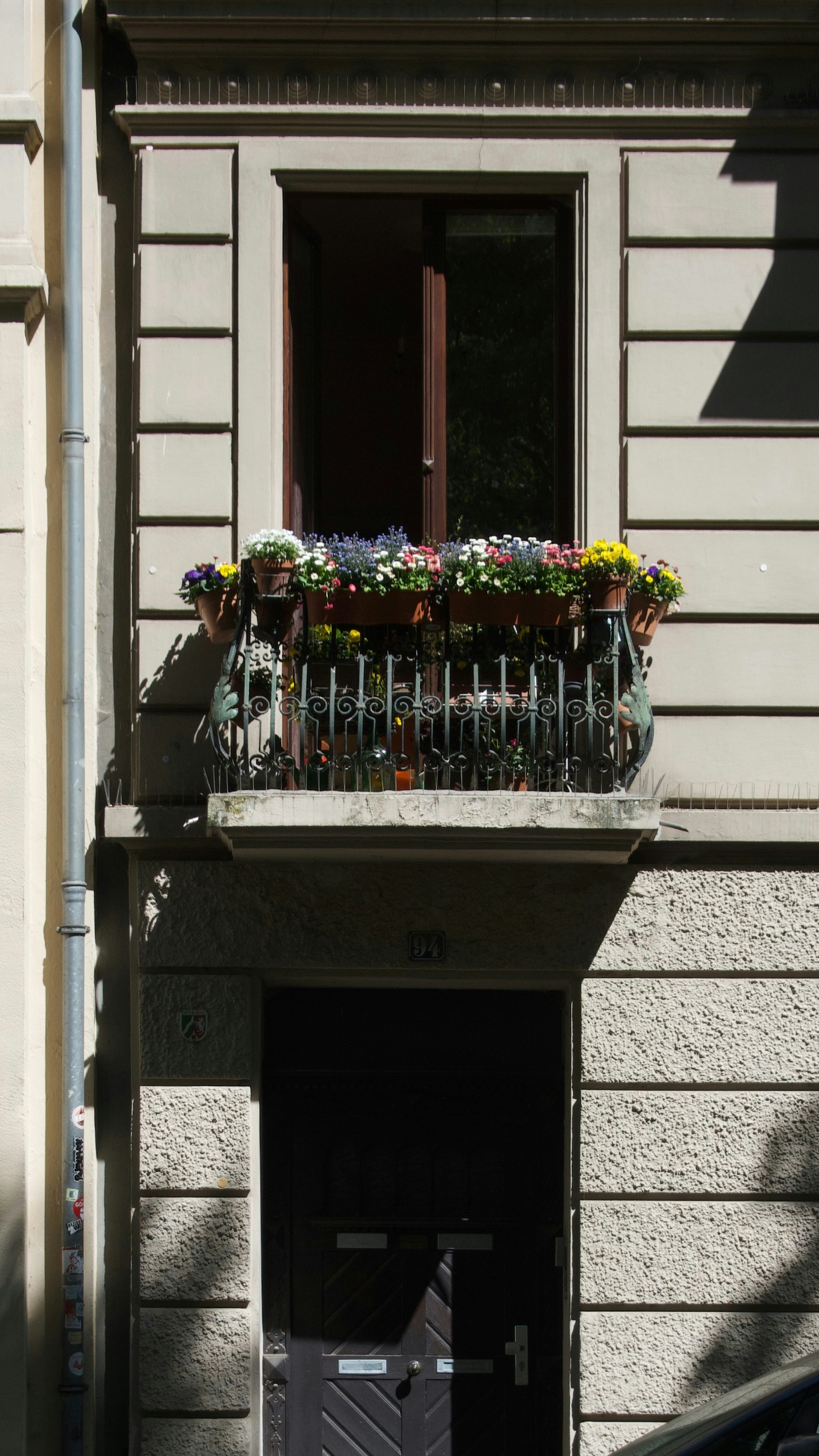Balcony Bloom: A Quiet Florilege Over a Historic Doorway