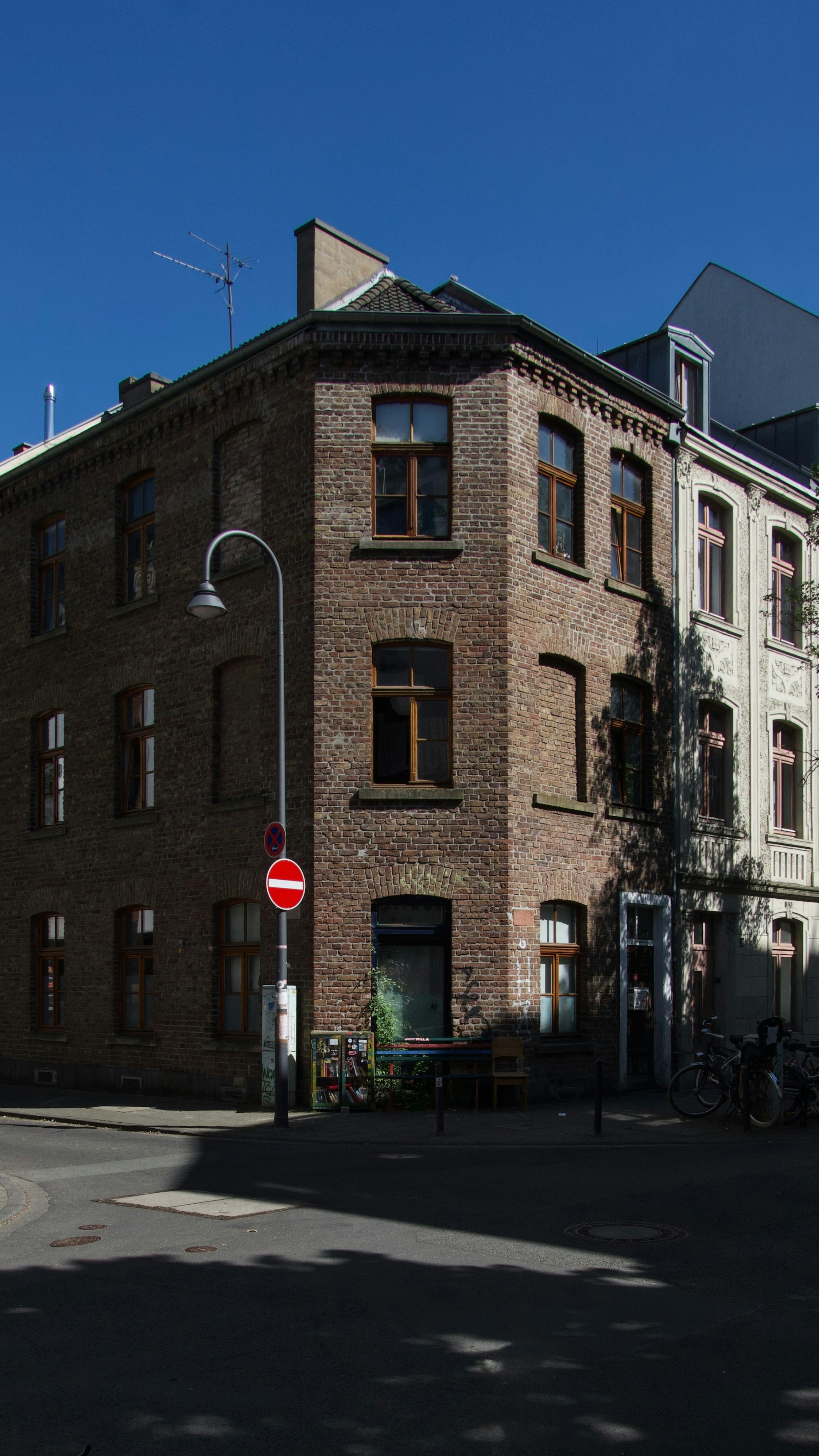 Brick Corner: Sunlit Facade Amid Quiet Street