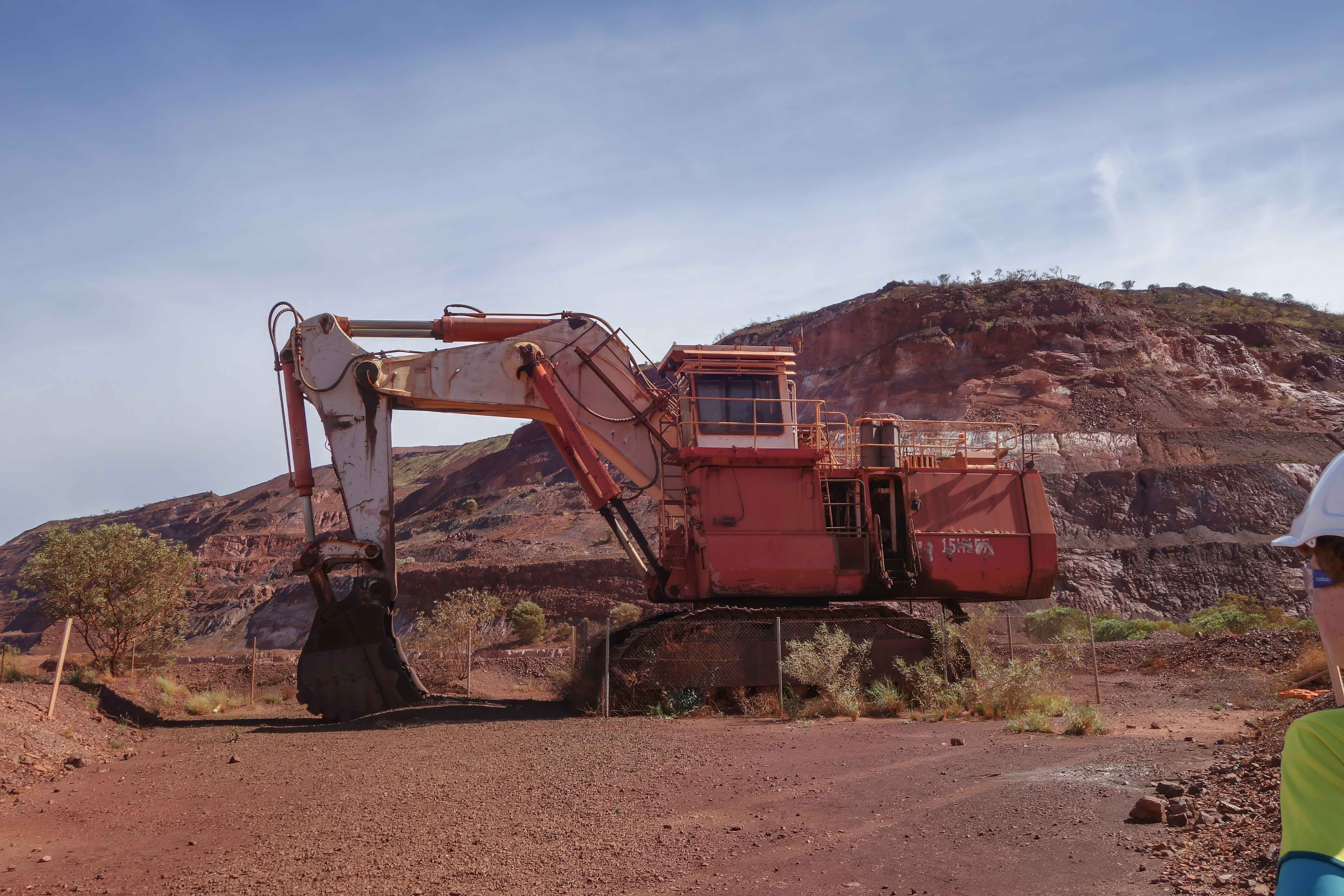 Giant excavator at work against a red rock backdrop