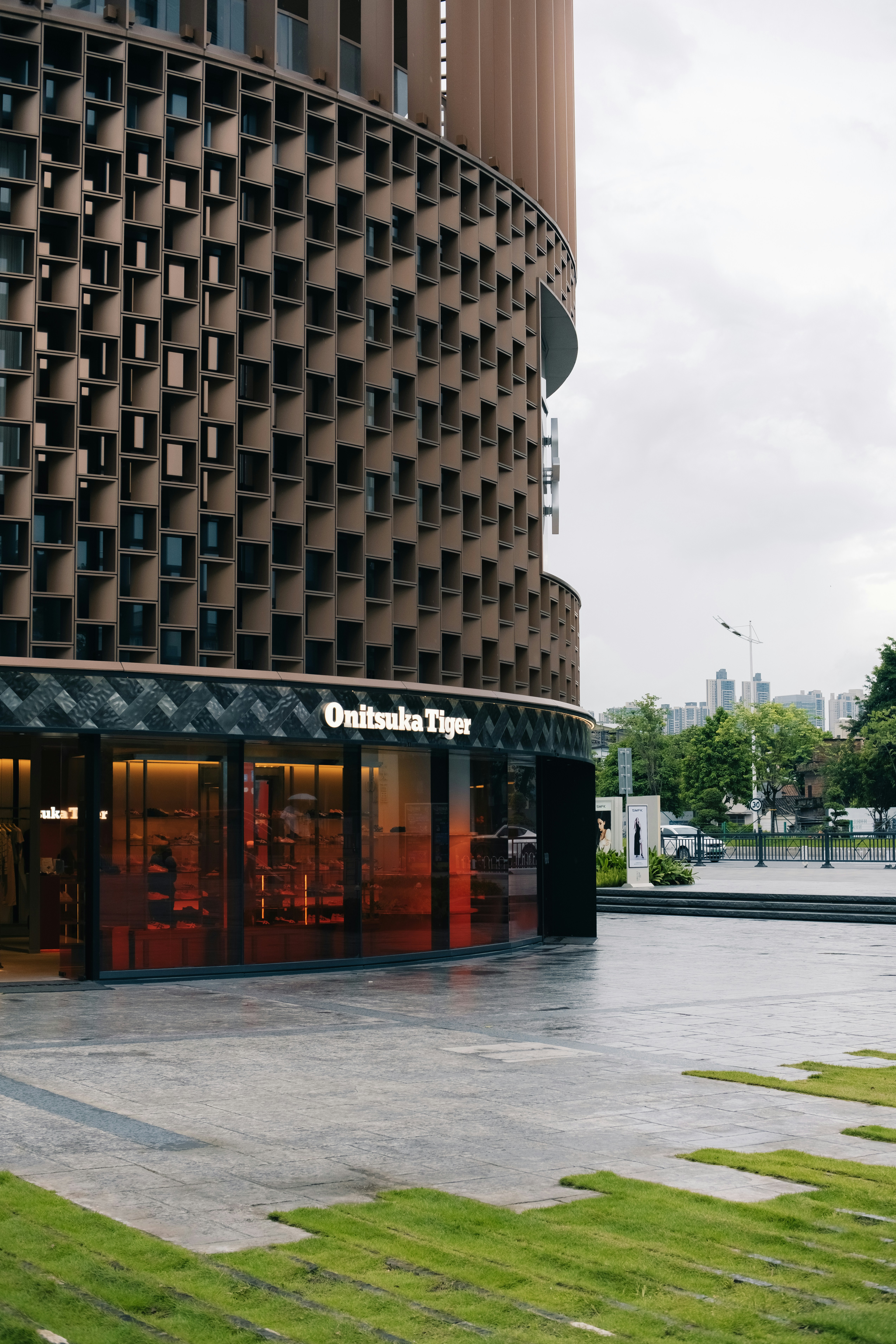 Circular Facade of Onitsuka Tiger Building: Warm Glow Through Glass