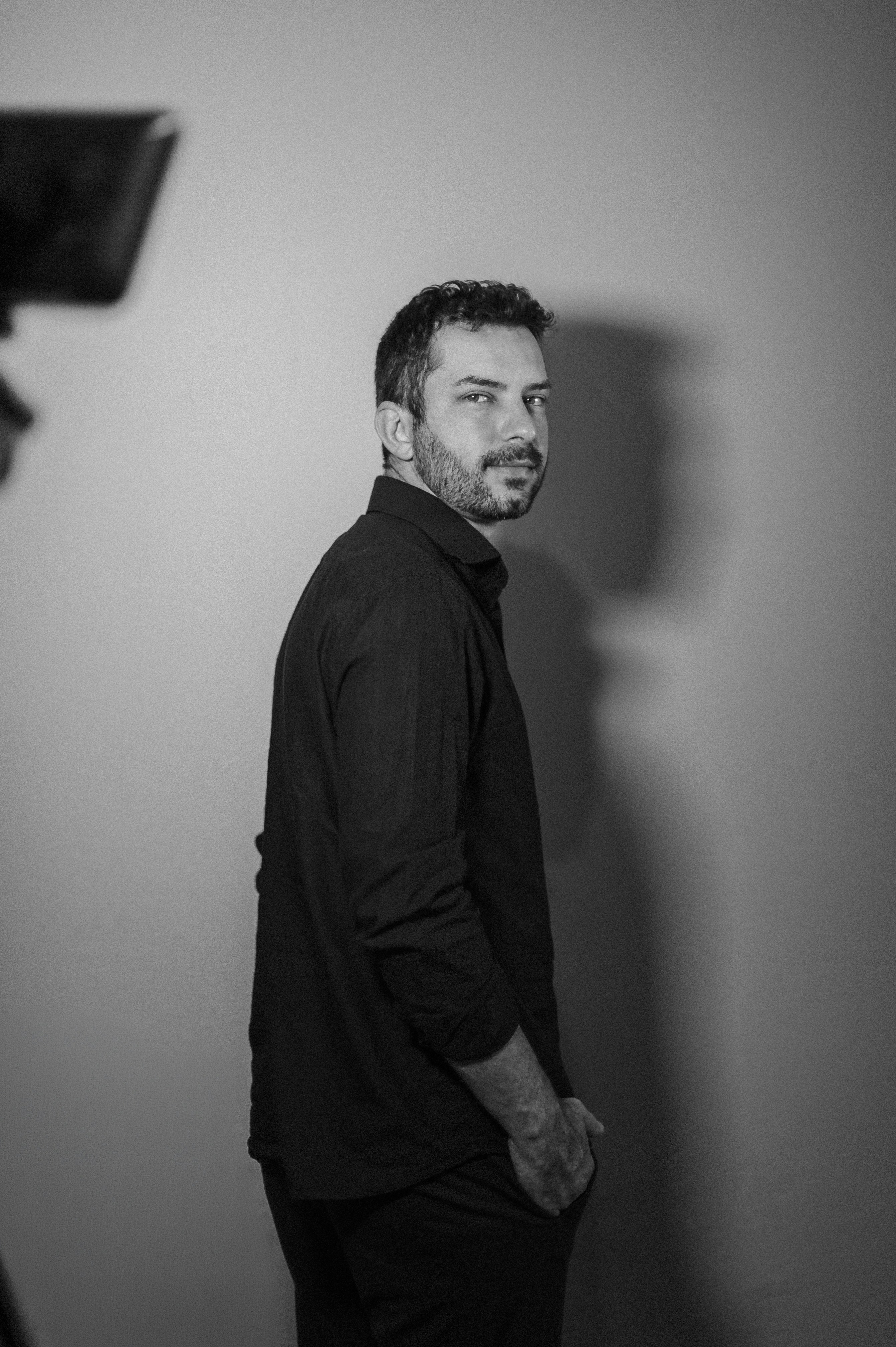Portrait in Shadow: A Quiet Gaze Against Studio Wall