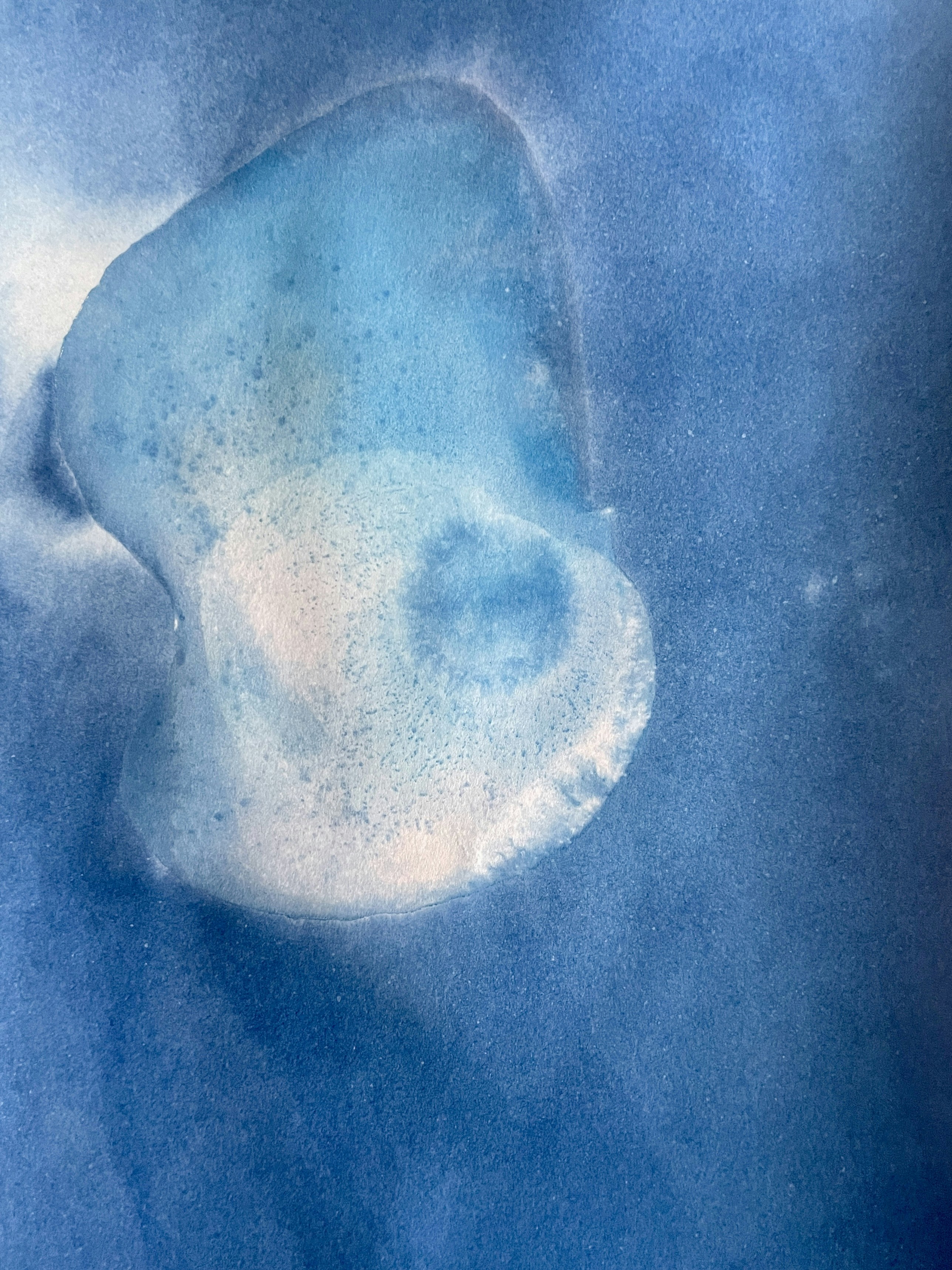 Soft blue watercolor texture with pale circular form and subtle grain; abstract art study. A logo-like abstract watercolor piece.