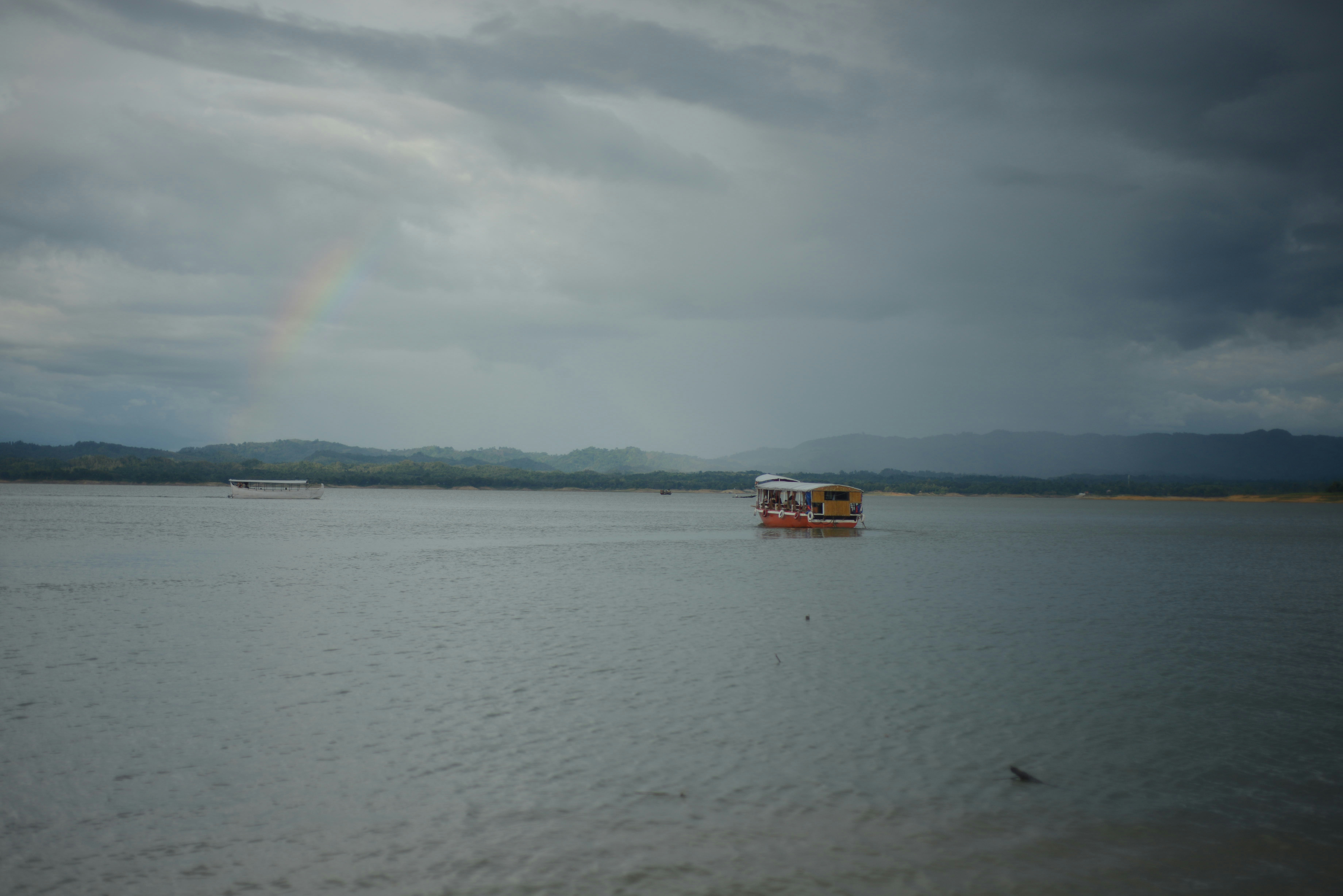A Quiet Boat Under a Faint Rainbow on Still Waters