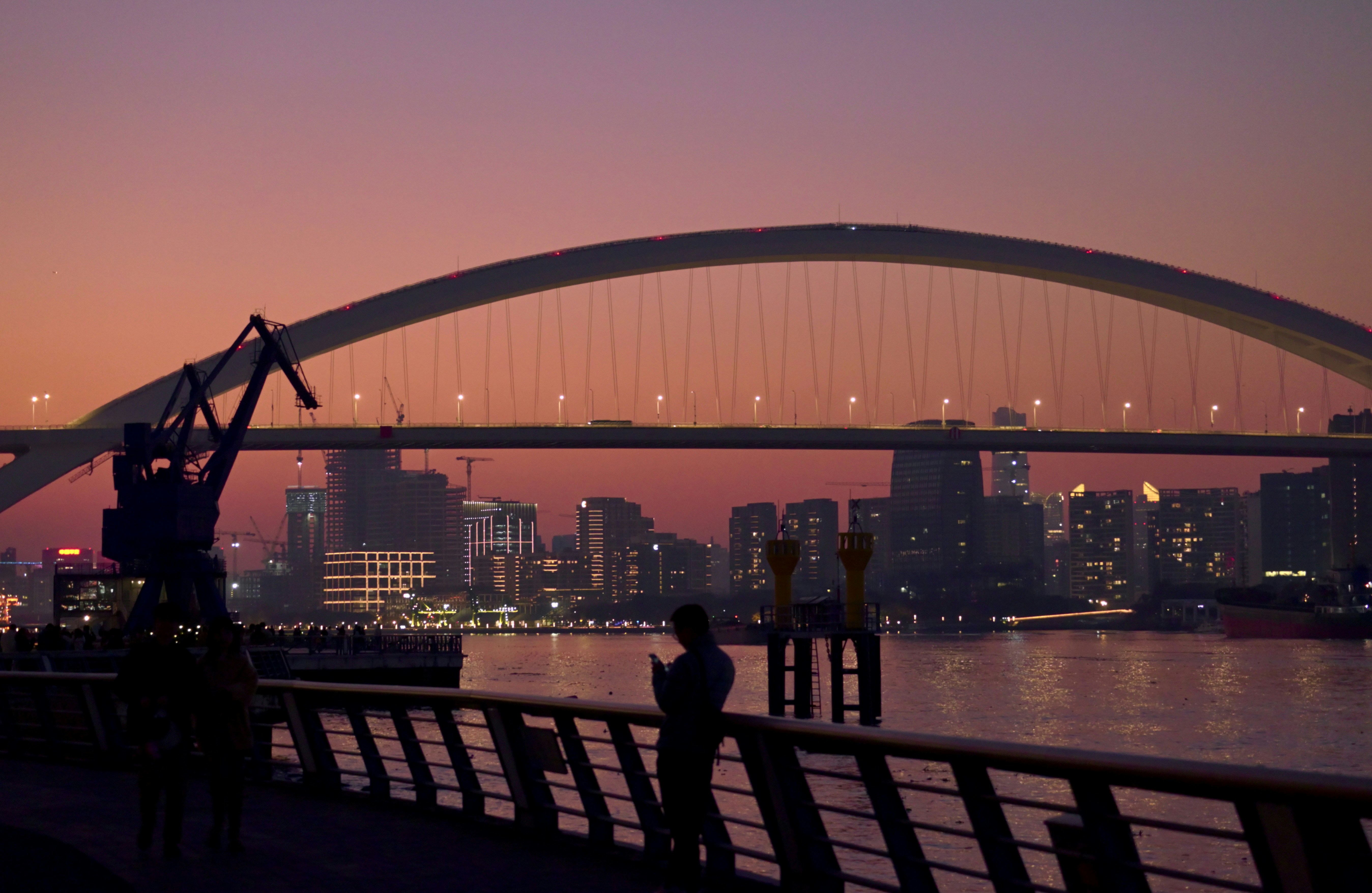Arc over the River: Dusk strollers by the Sculpted Bridge