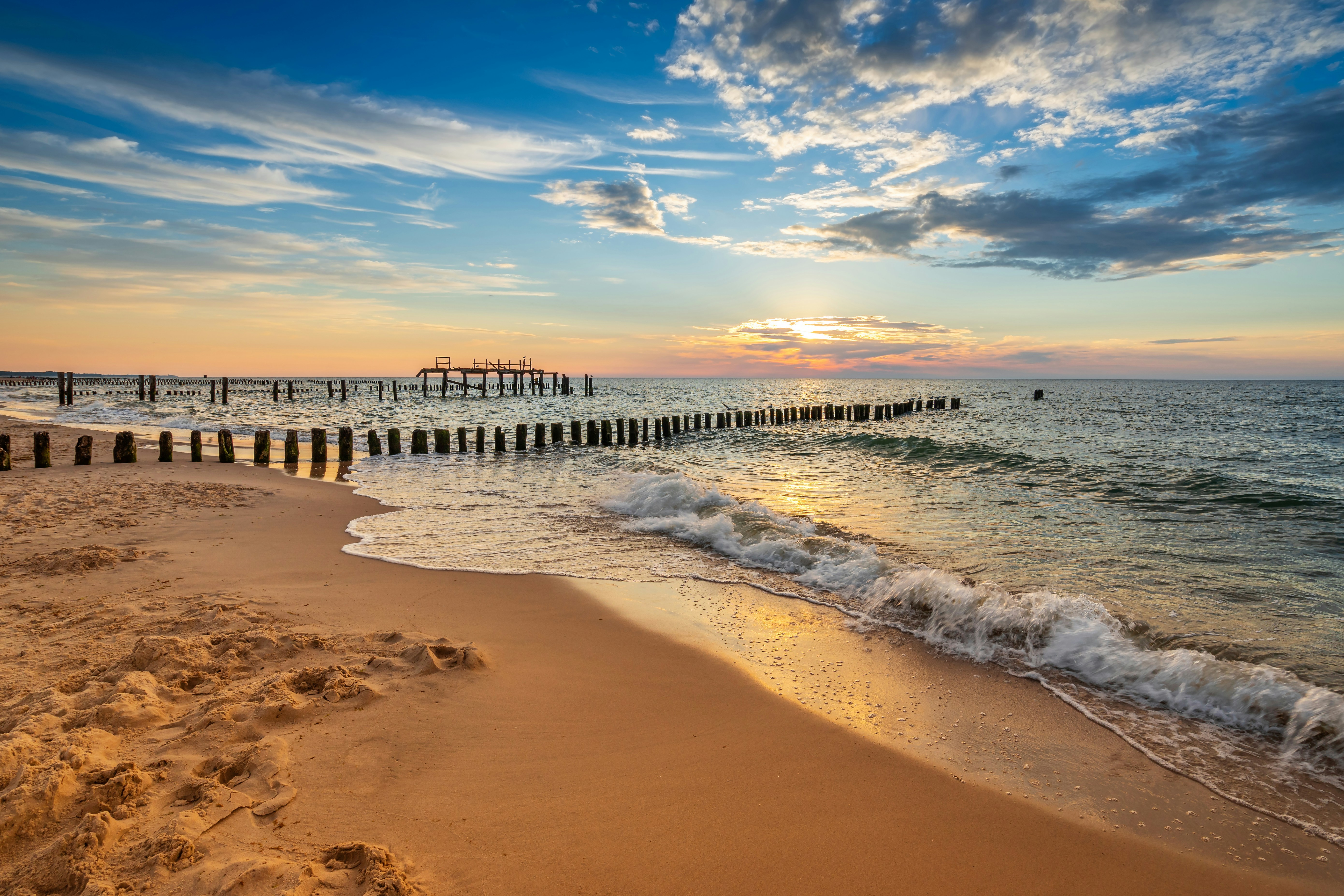Sunlit Breakers and Pier Silhouette at Golden Hour