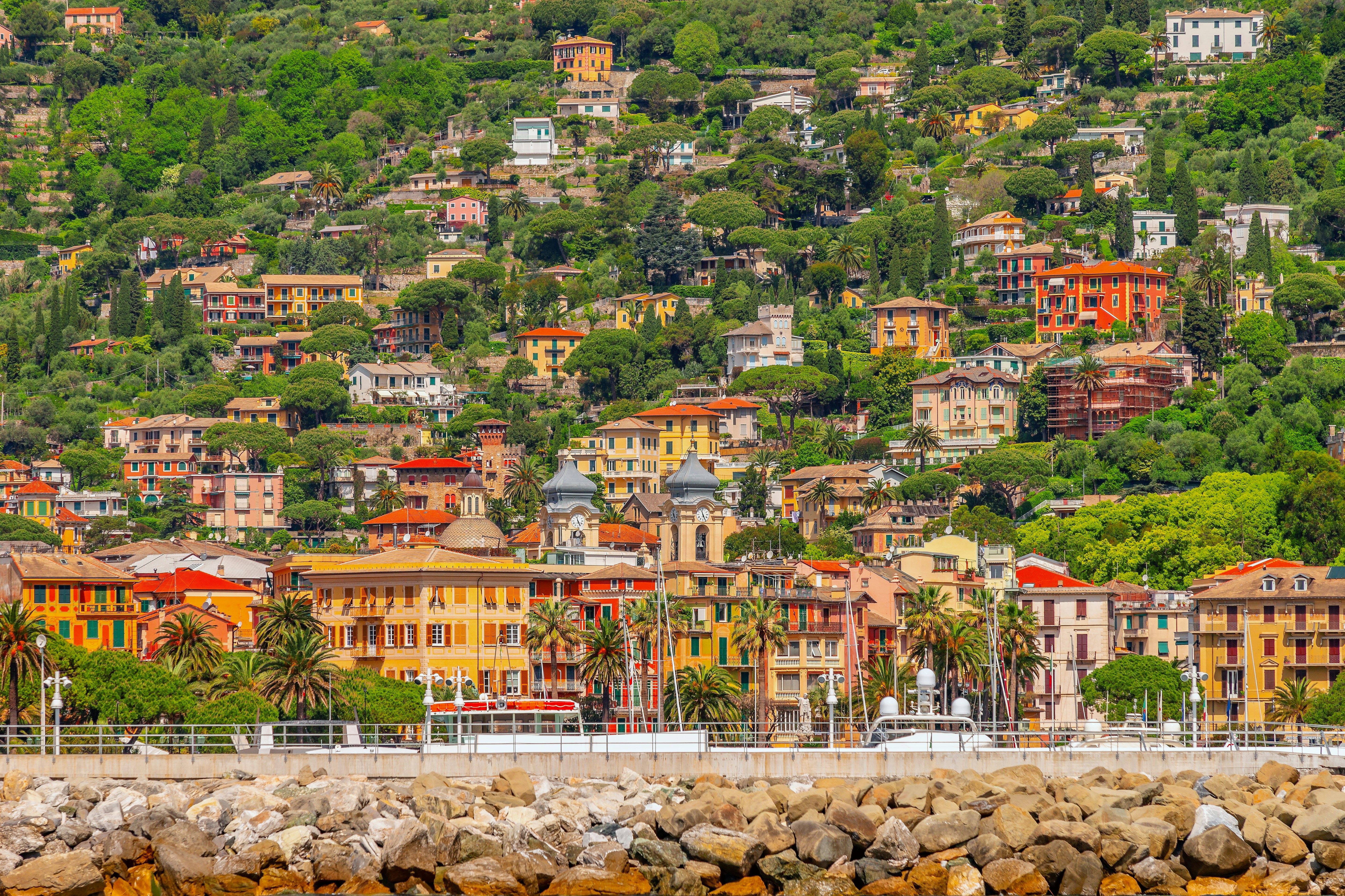Colorful hillside village by the sea with rocky promenade