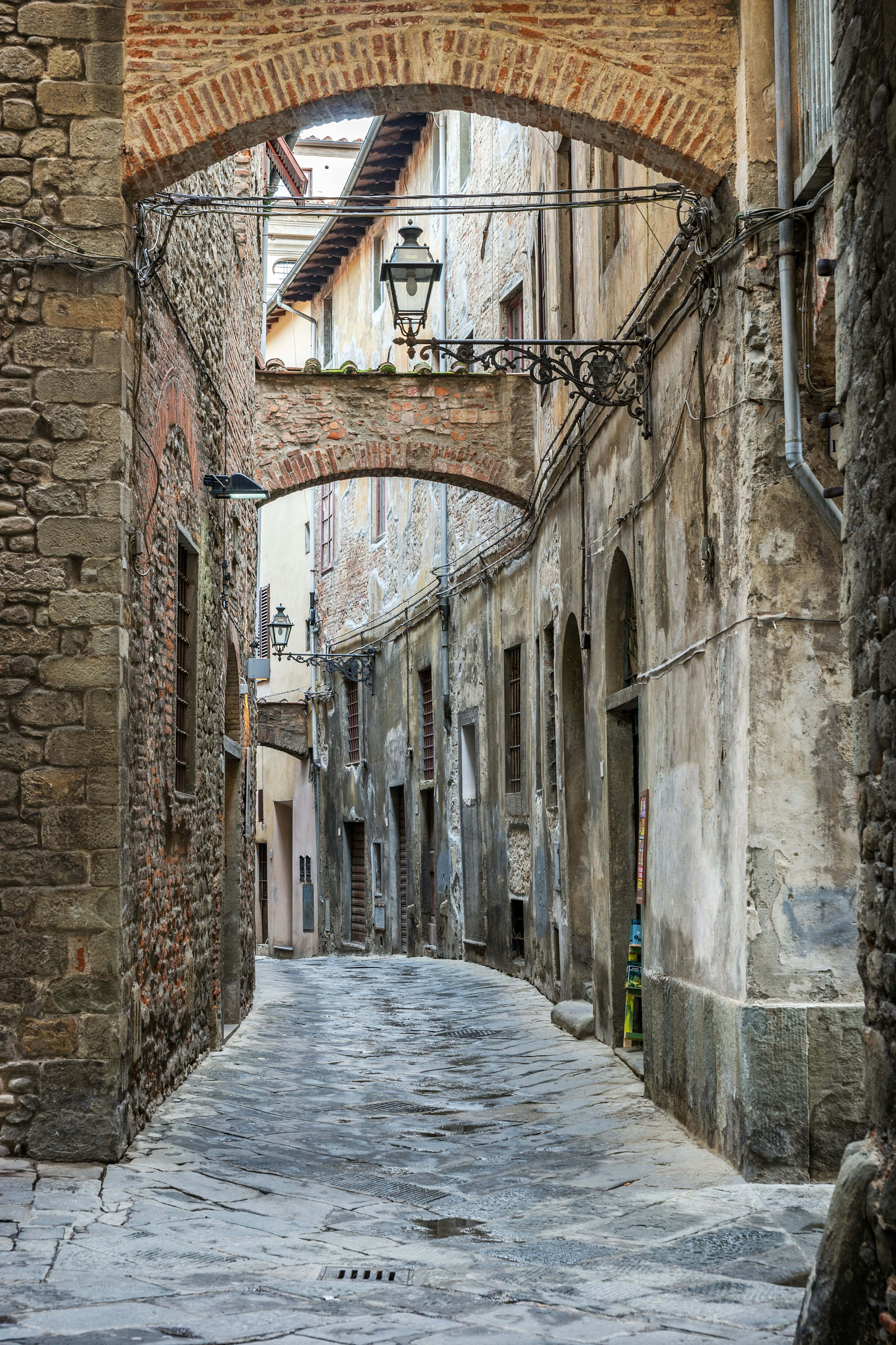 Worn Archways and Narrow Cobblestones: A Quiet European Alley Between Timeworn Facades