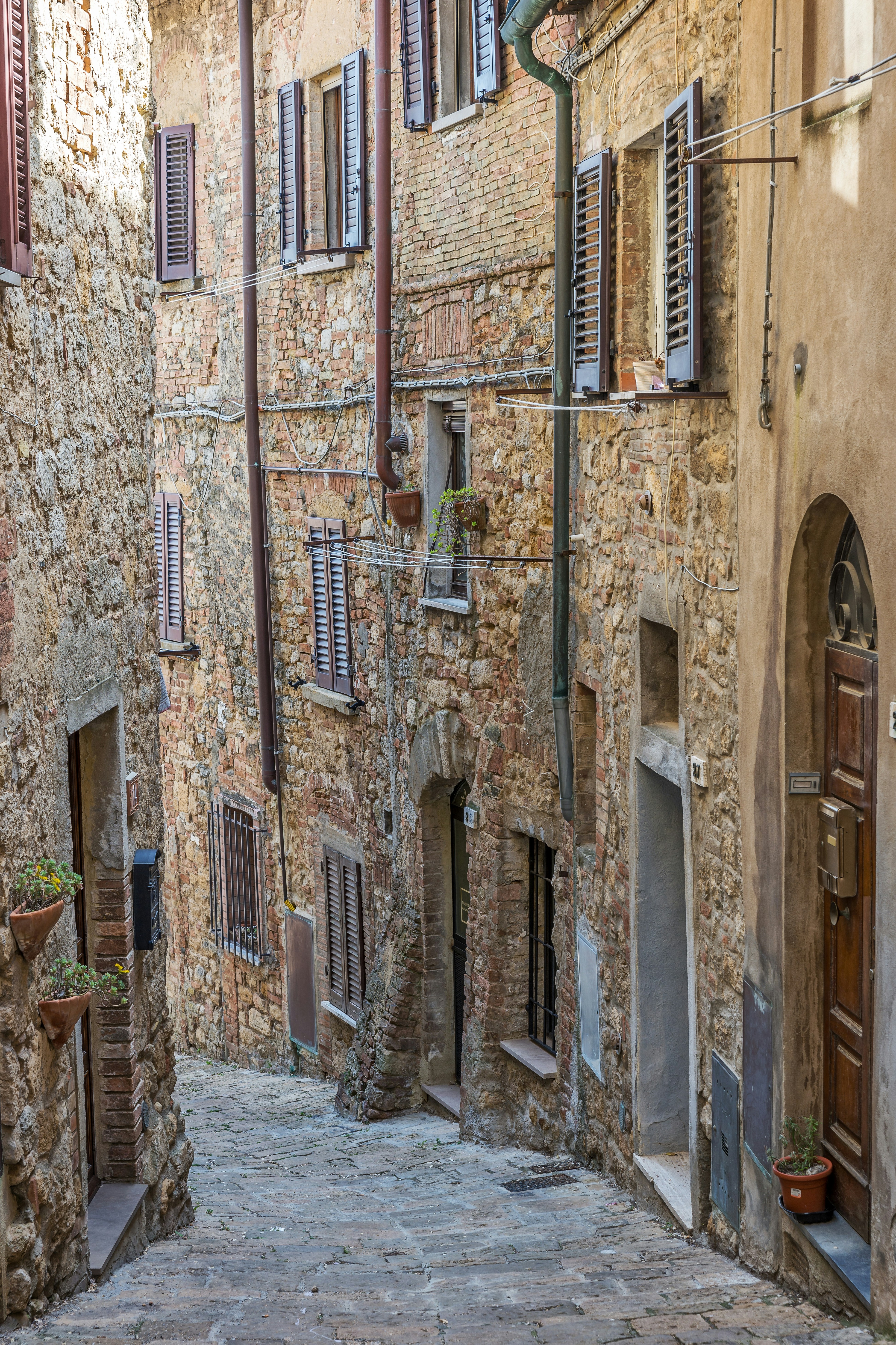 Sunlit Stone Alley: A Quiet Confluence of Doors and Windows