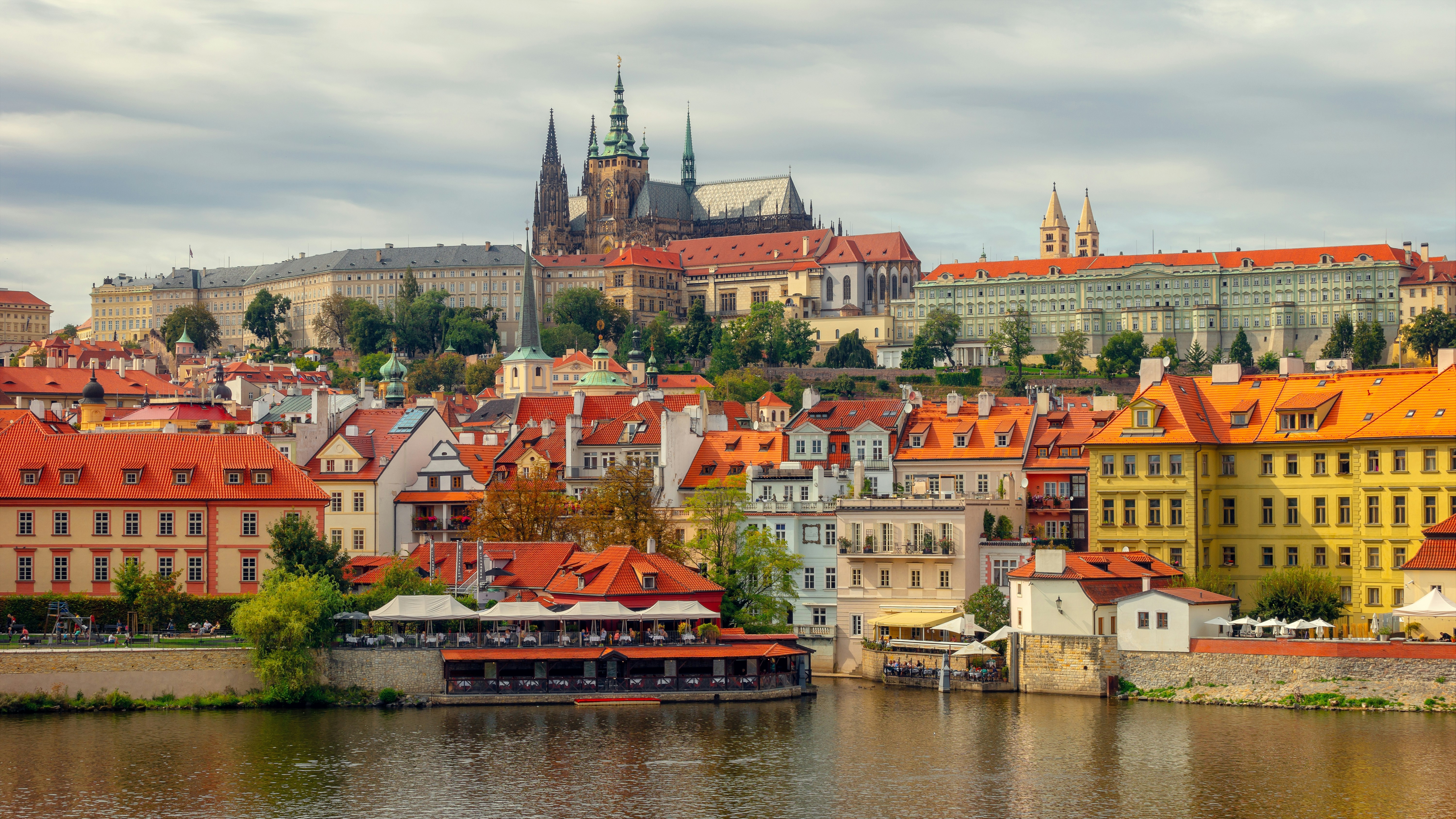 Riverside Castle Vista: Colorful Prague Rooftops Framing a Majestic Fortress