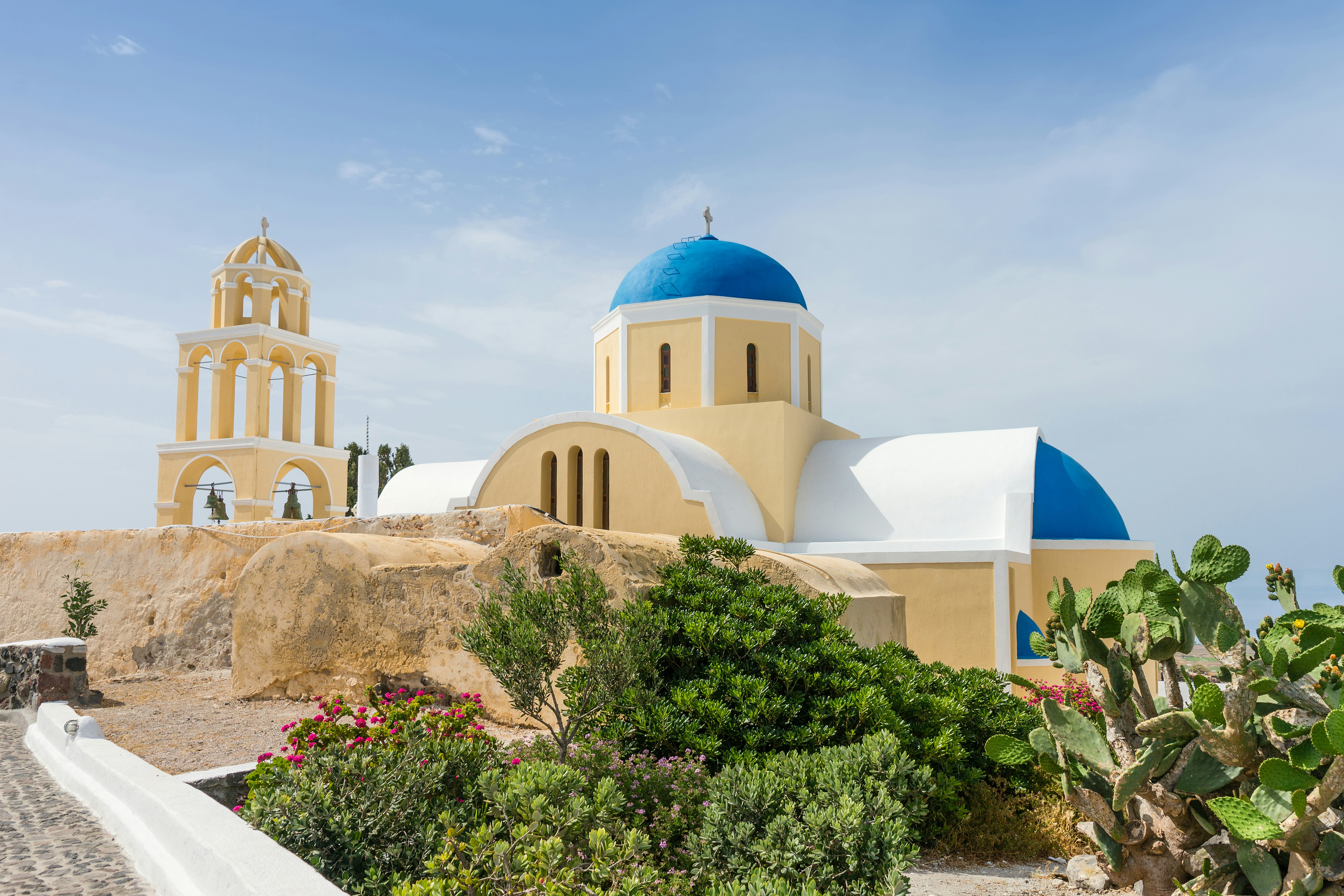 Blue-domed chapel in sunlit Aegean-style complex
