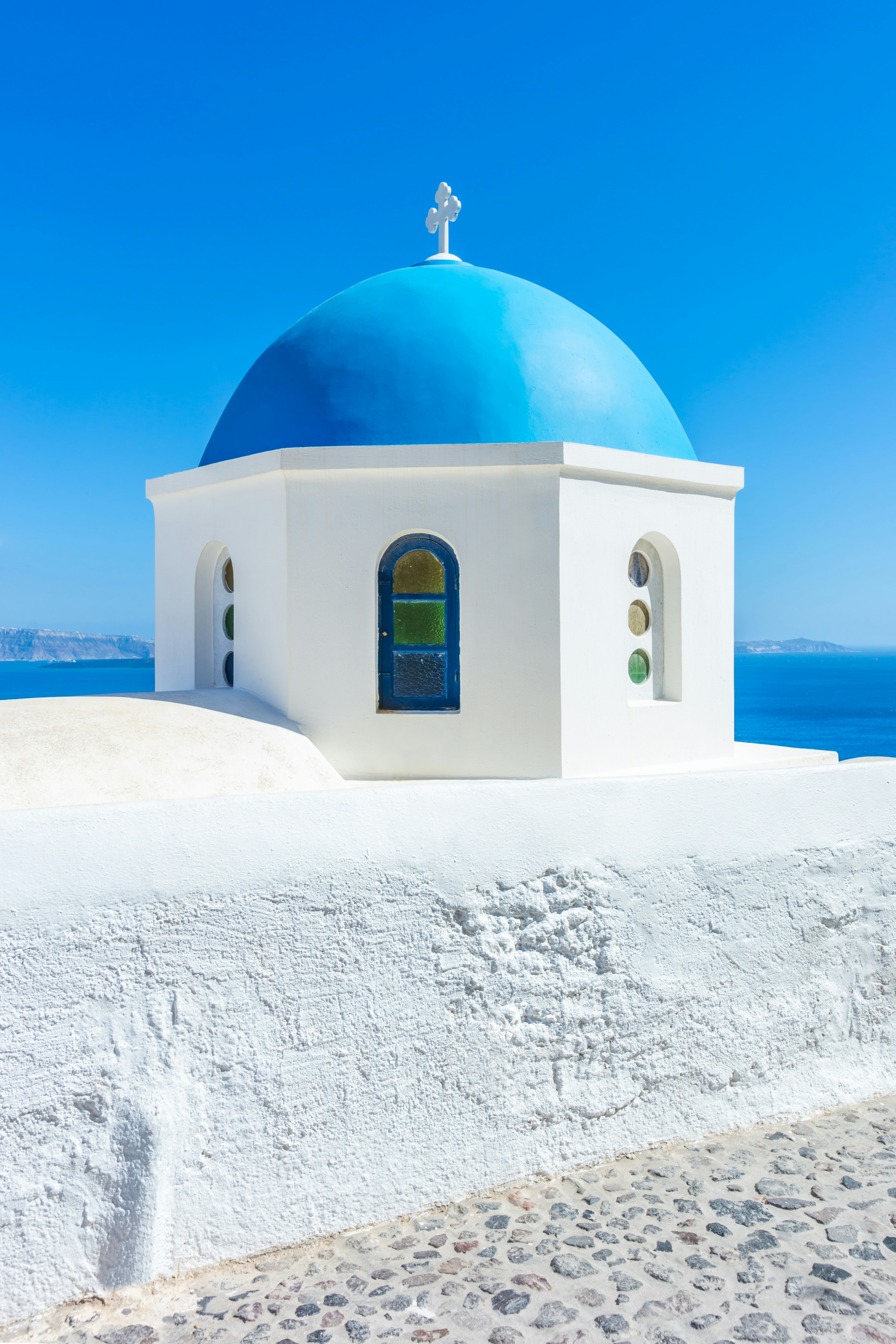Blue Dome on White Facade: A Santorini Chapel Against A Sea Sky