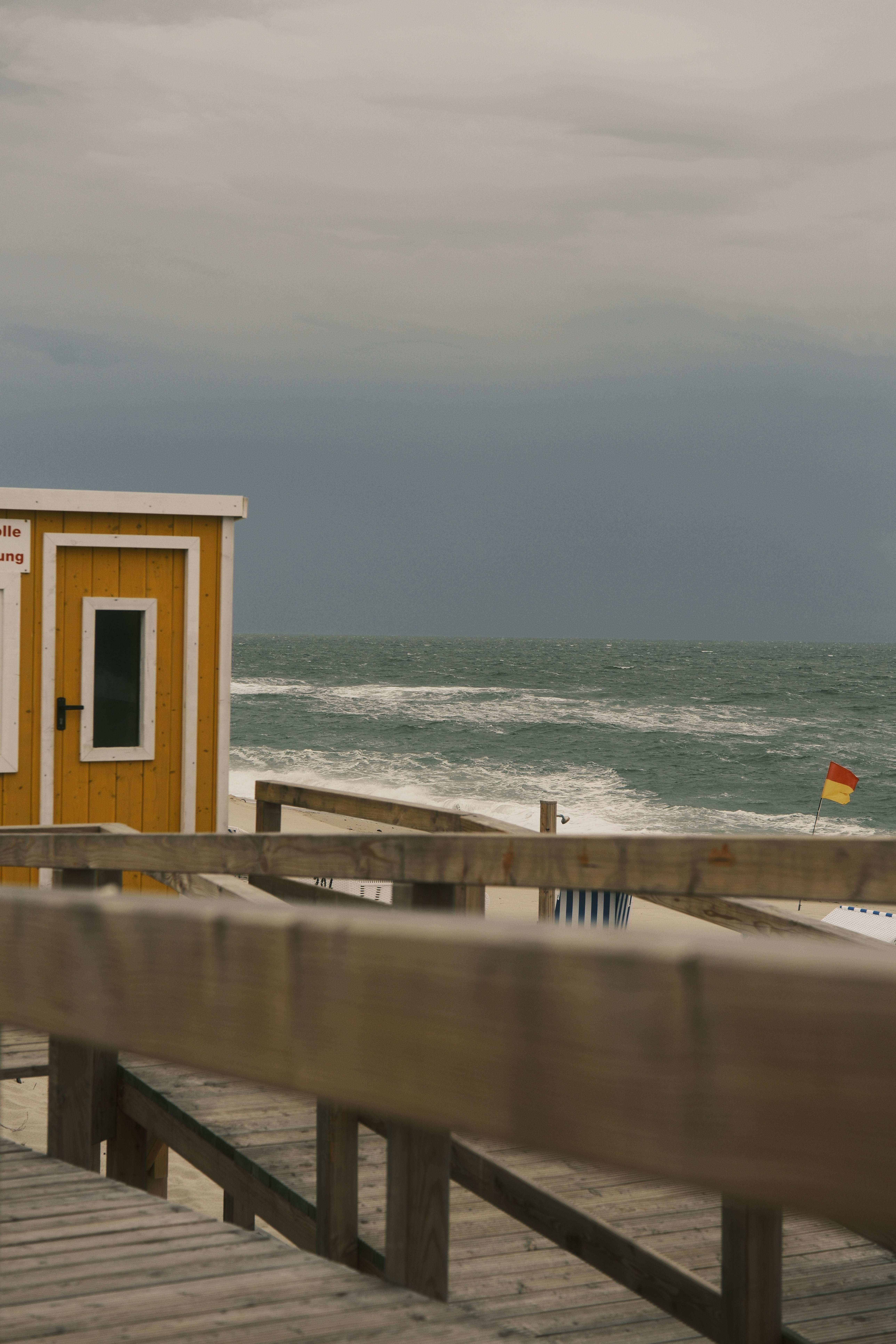 Coastal Watch: A Wooden Boardwalk Faces the Open Sea Under Gray Skies