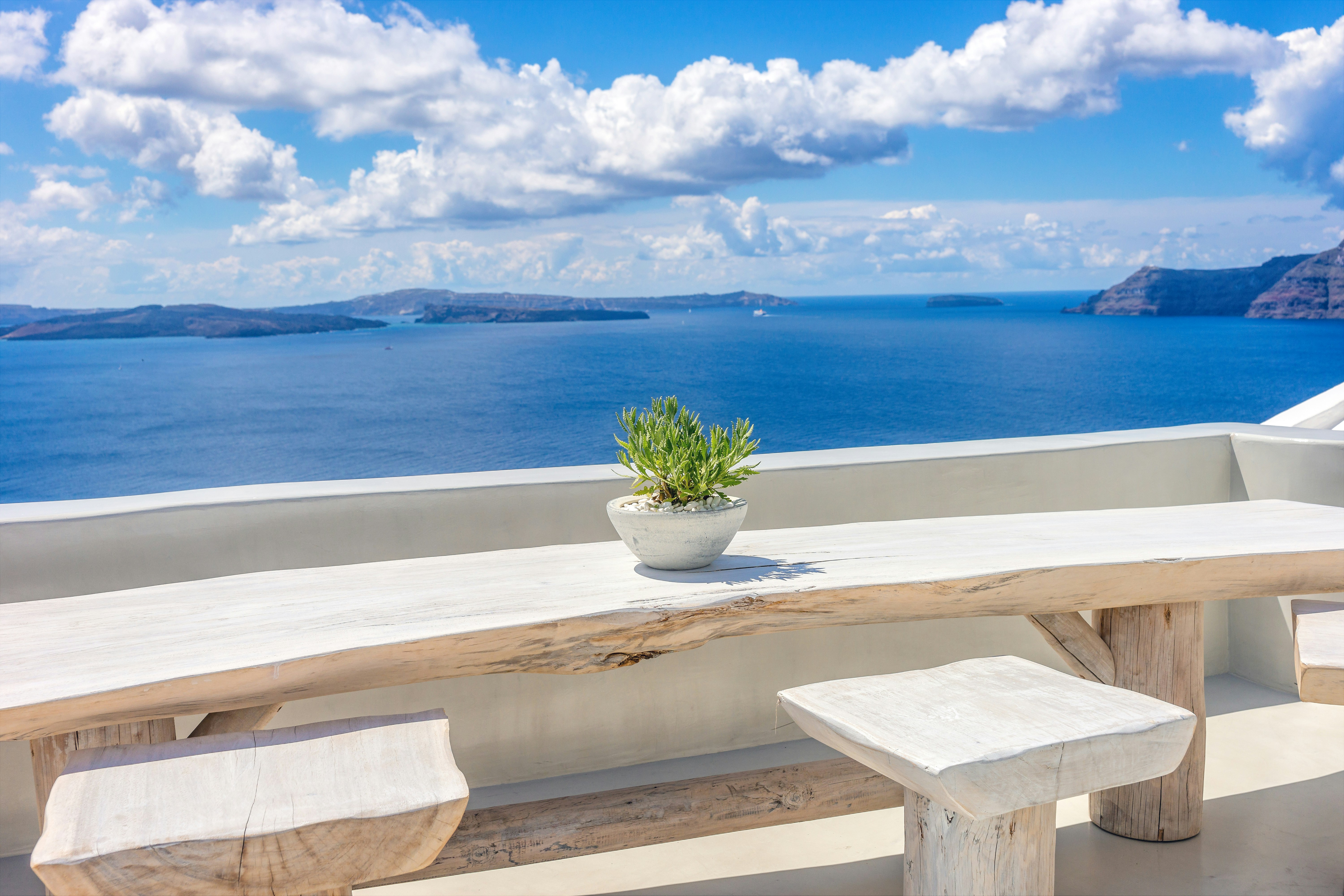 Sunlit Terrace Over Aegean: Wooden Table Framing the Sea