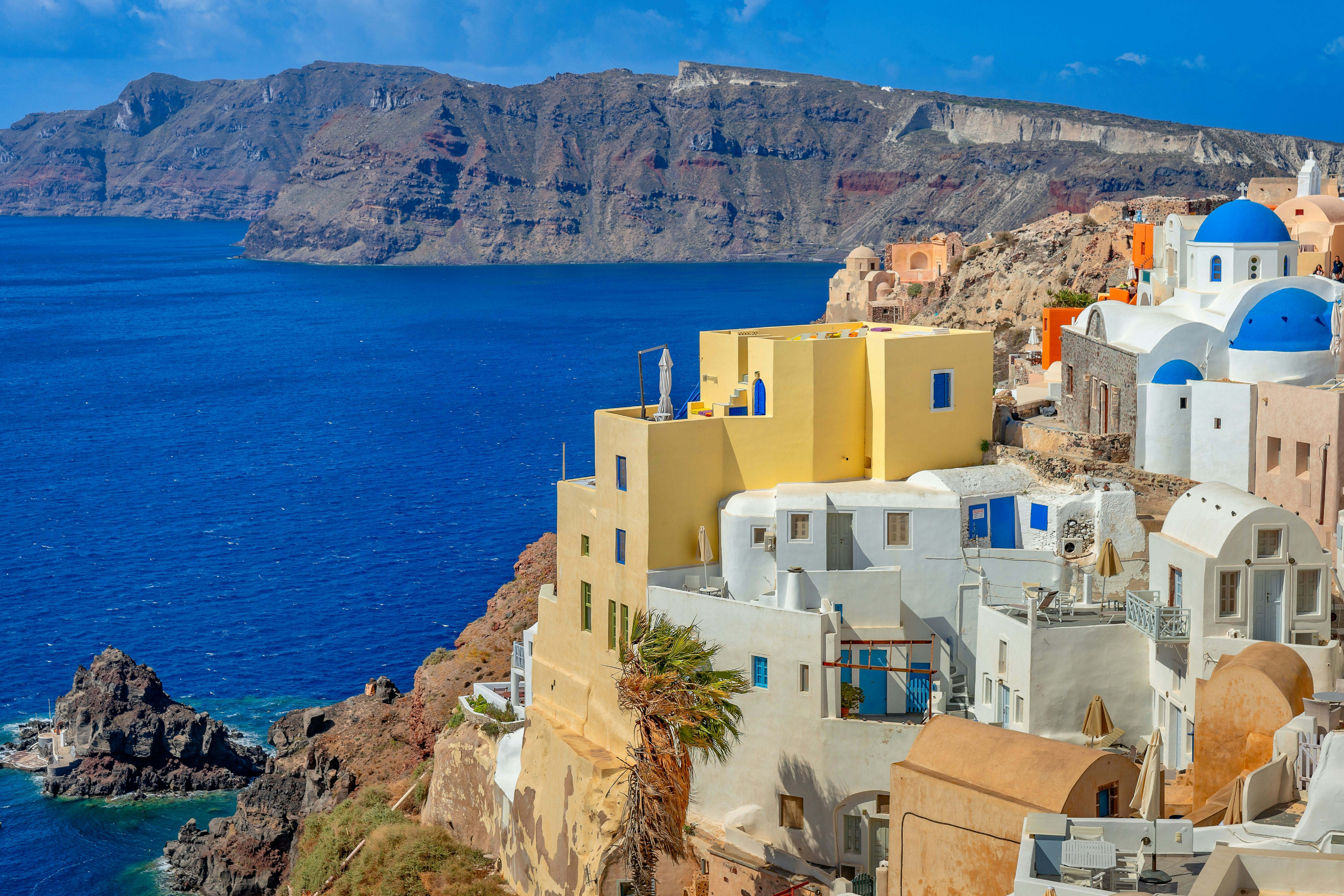 Sunlit Cycladic Village Clinging to the Cliff Overlooking Aegean Blues