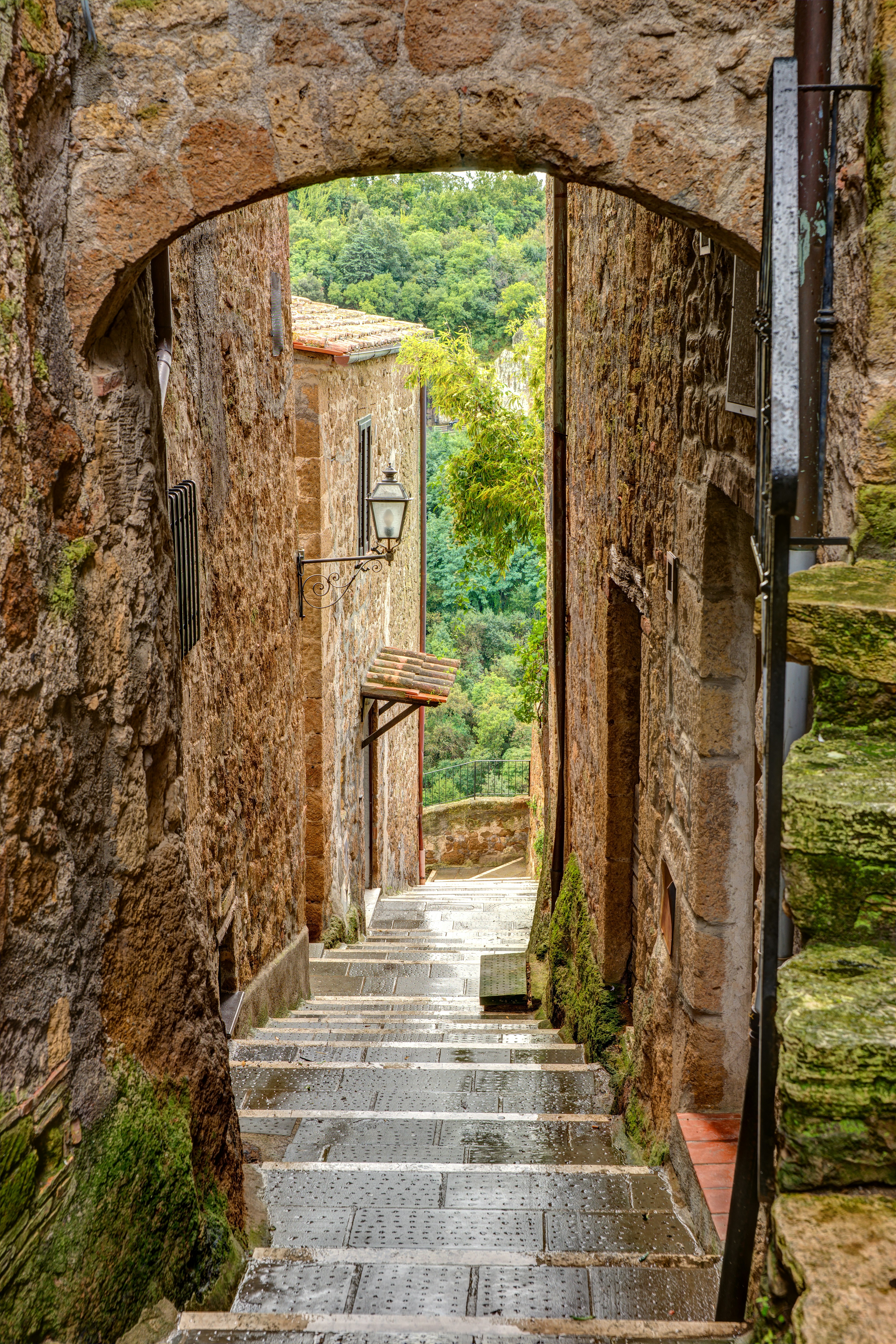 Stone Archway Corridor: Narrow Steps Descend into Verdant Light