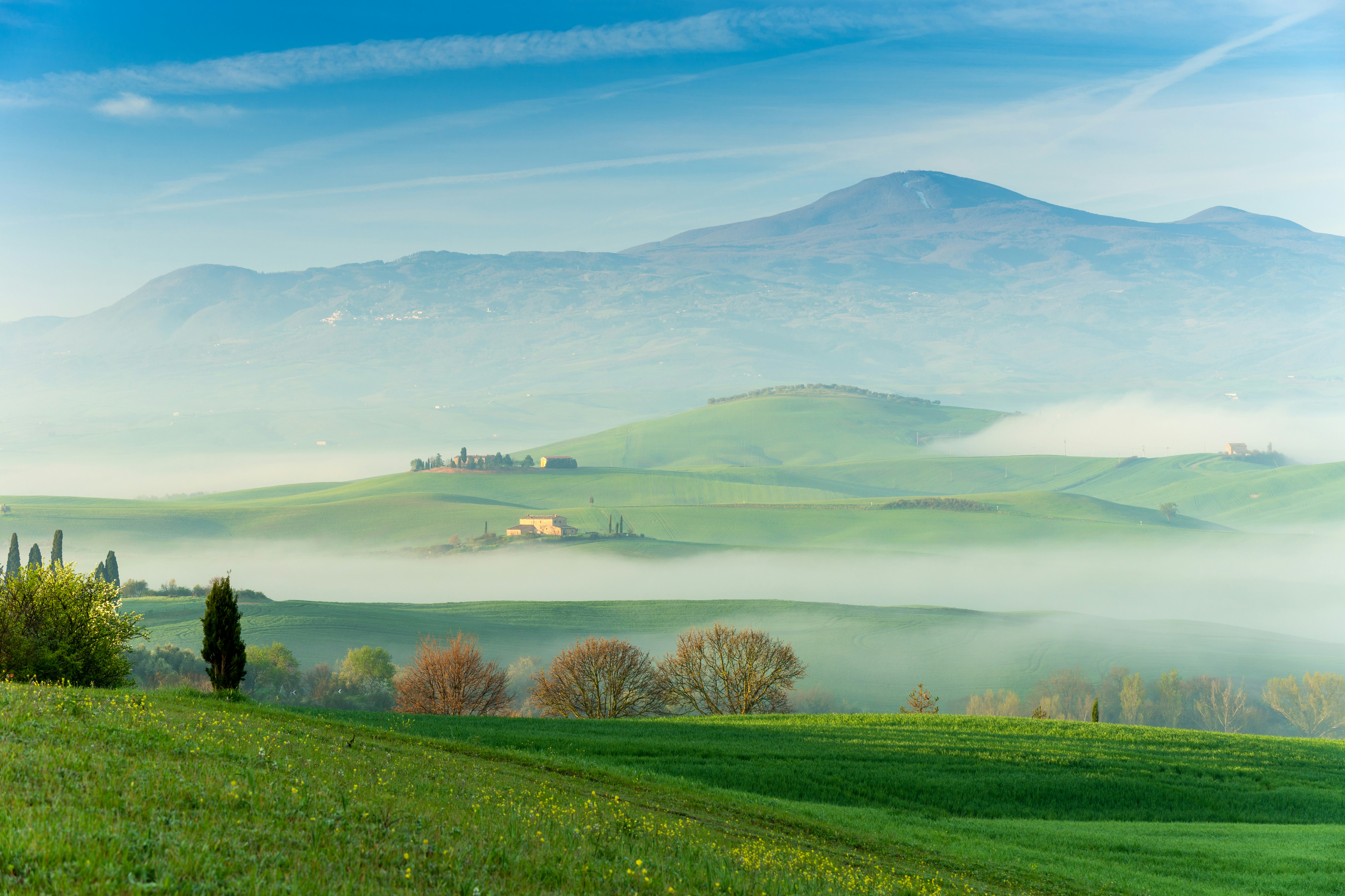 Mist on the rolling Tuscan Hills Beneath a Quiet Blue Sky