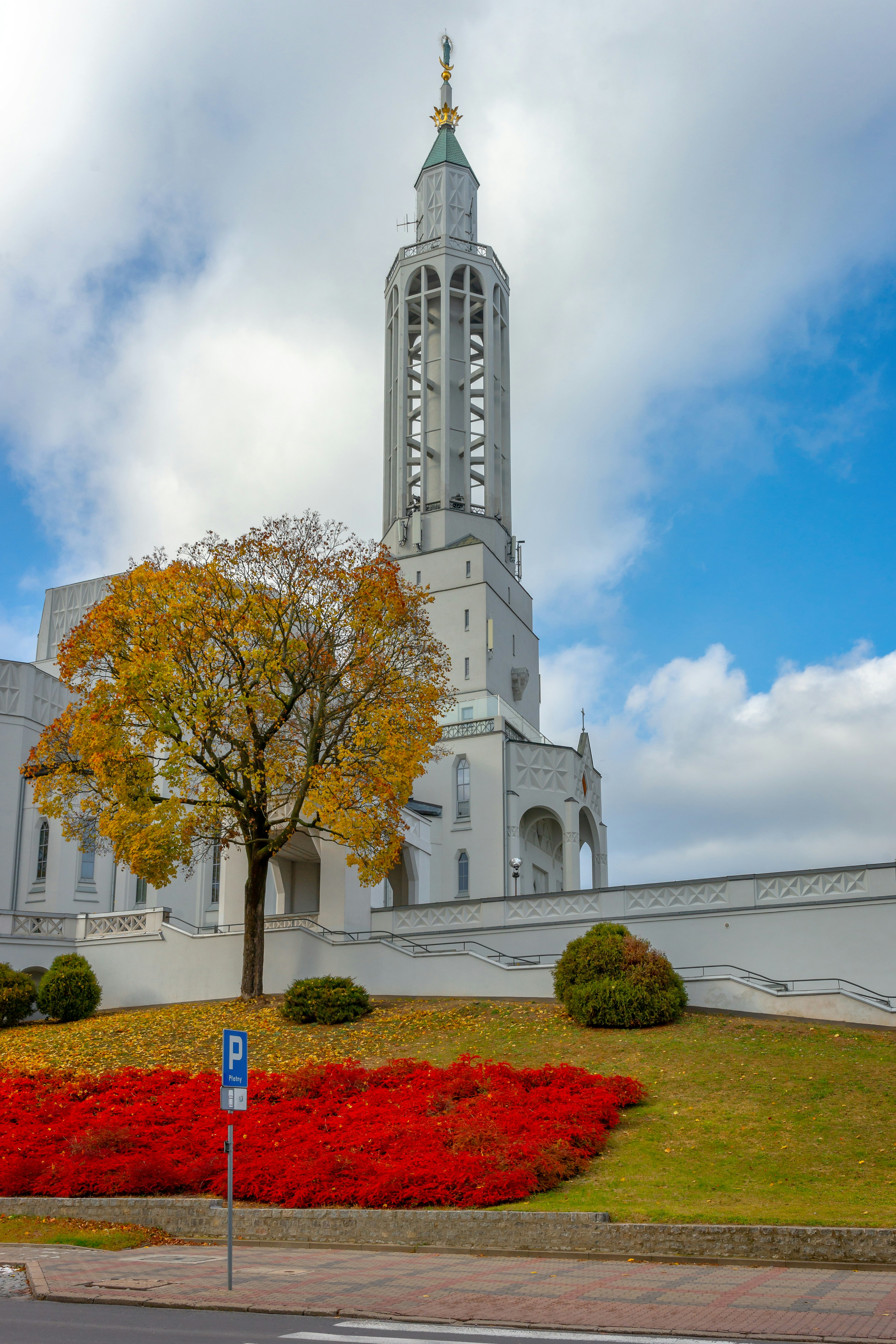 Towering White Chapel with Autumn Tree and Red Groundcover