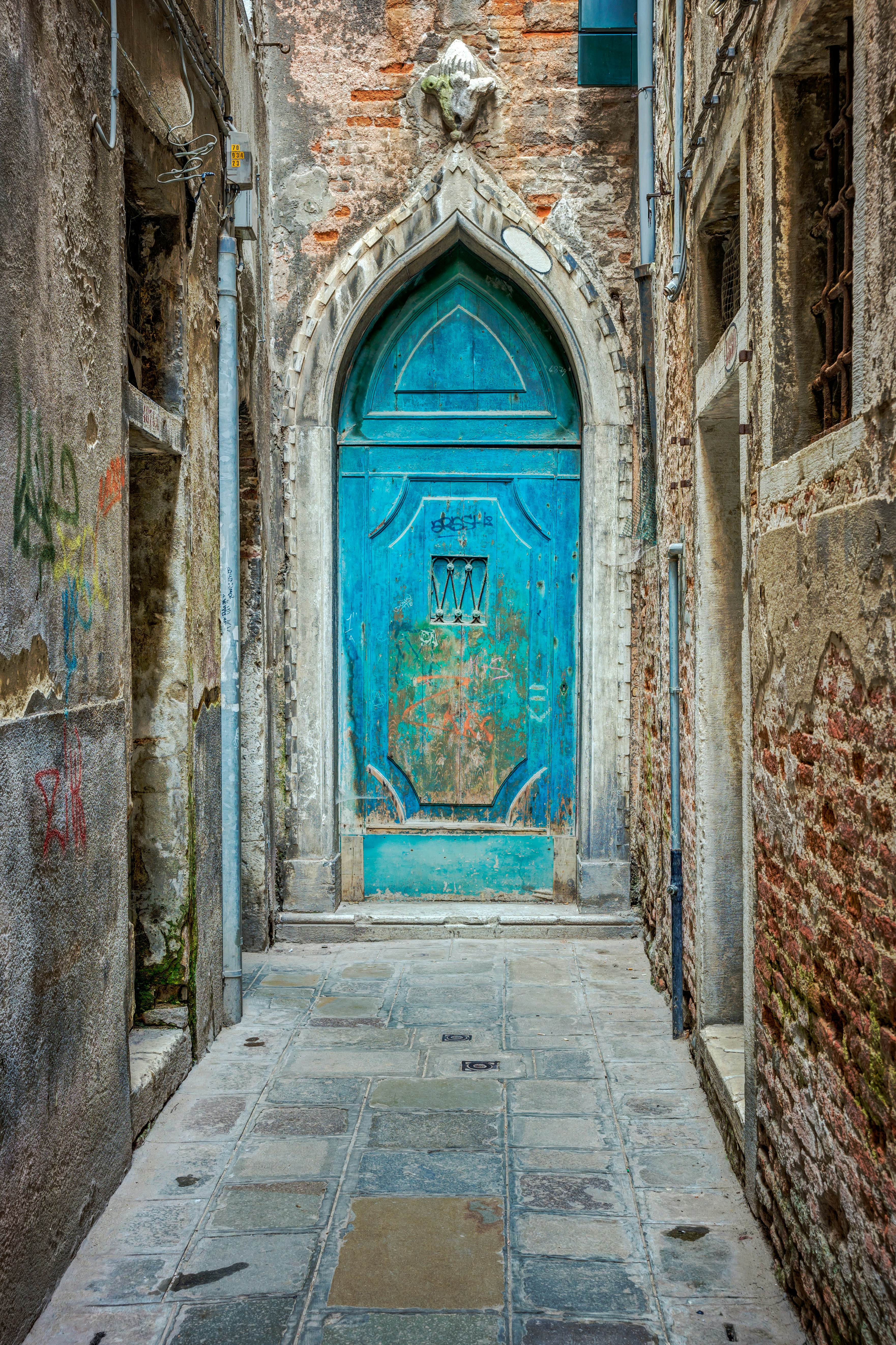 Weathered Blue Door in a Narrow Adobe Passageway