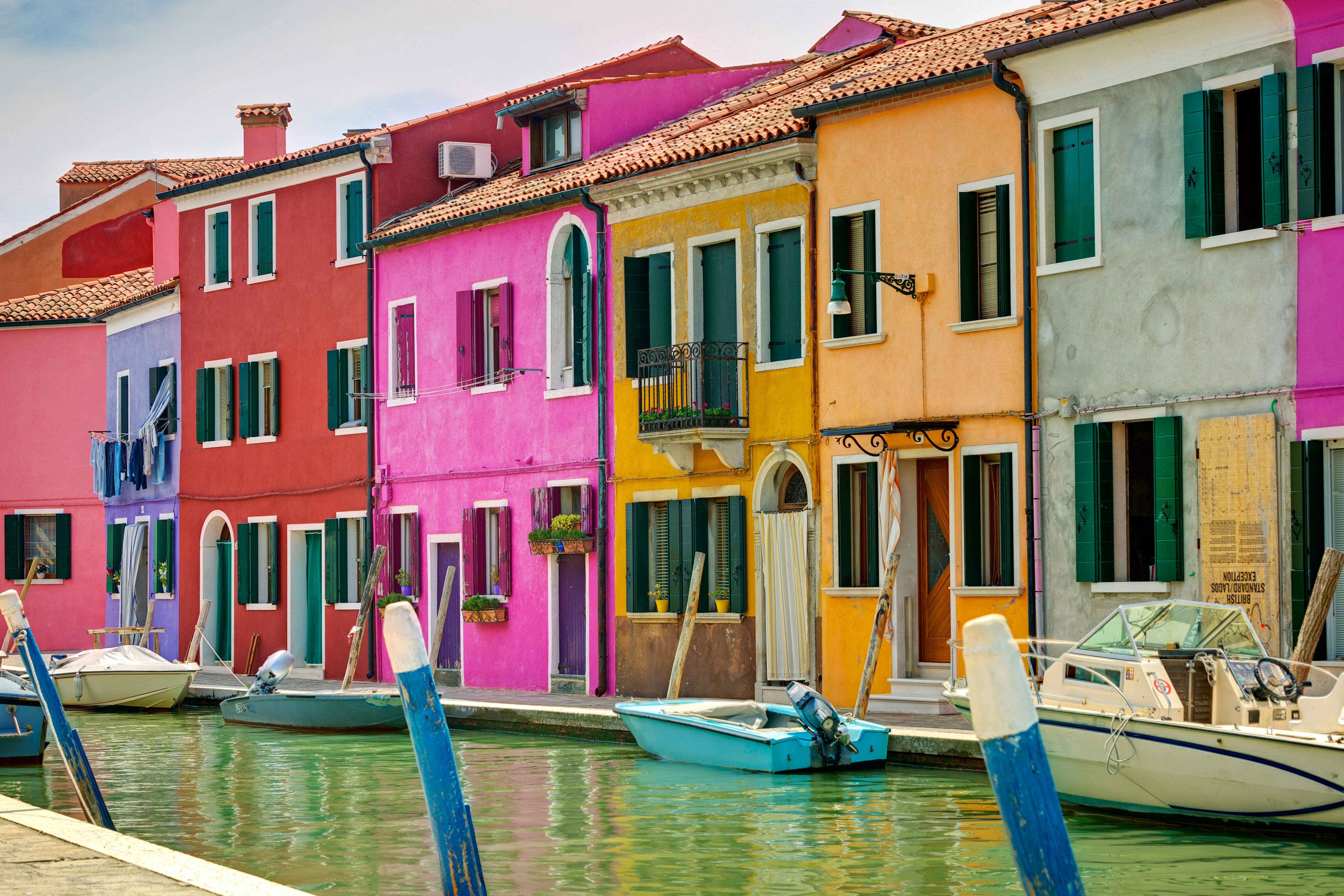 Chromatic Canalfront: A Row of Sunset-Hued Homes by Tranquil Waters