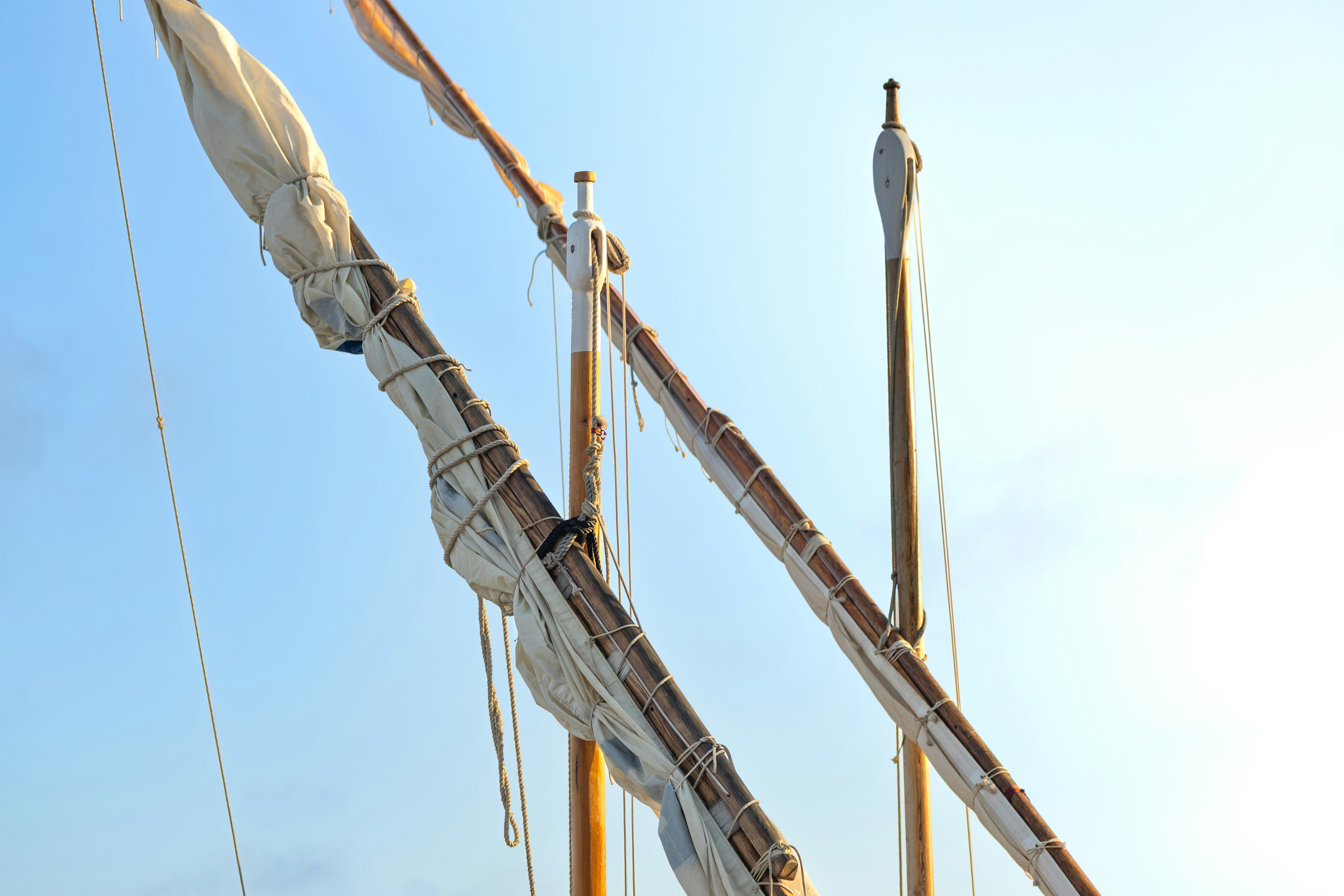 Sail Mast Lines Caught in Sunlight Against Clear Sky