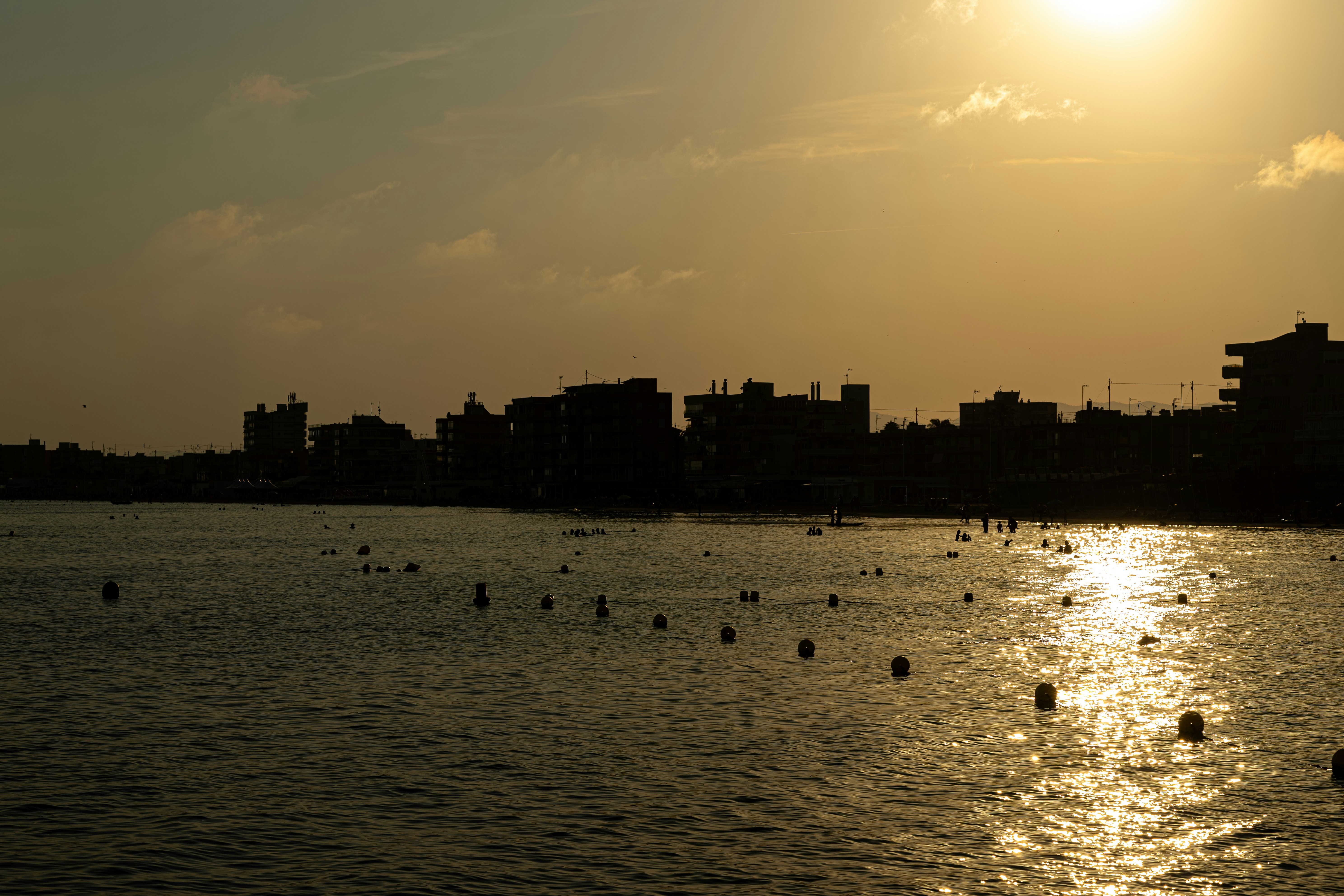 Sunlit silhouettes over a moored shoreline