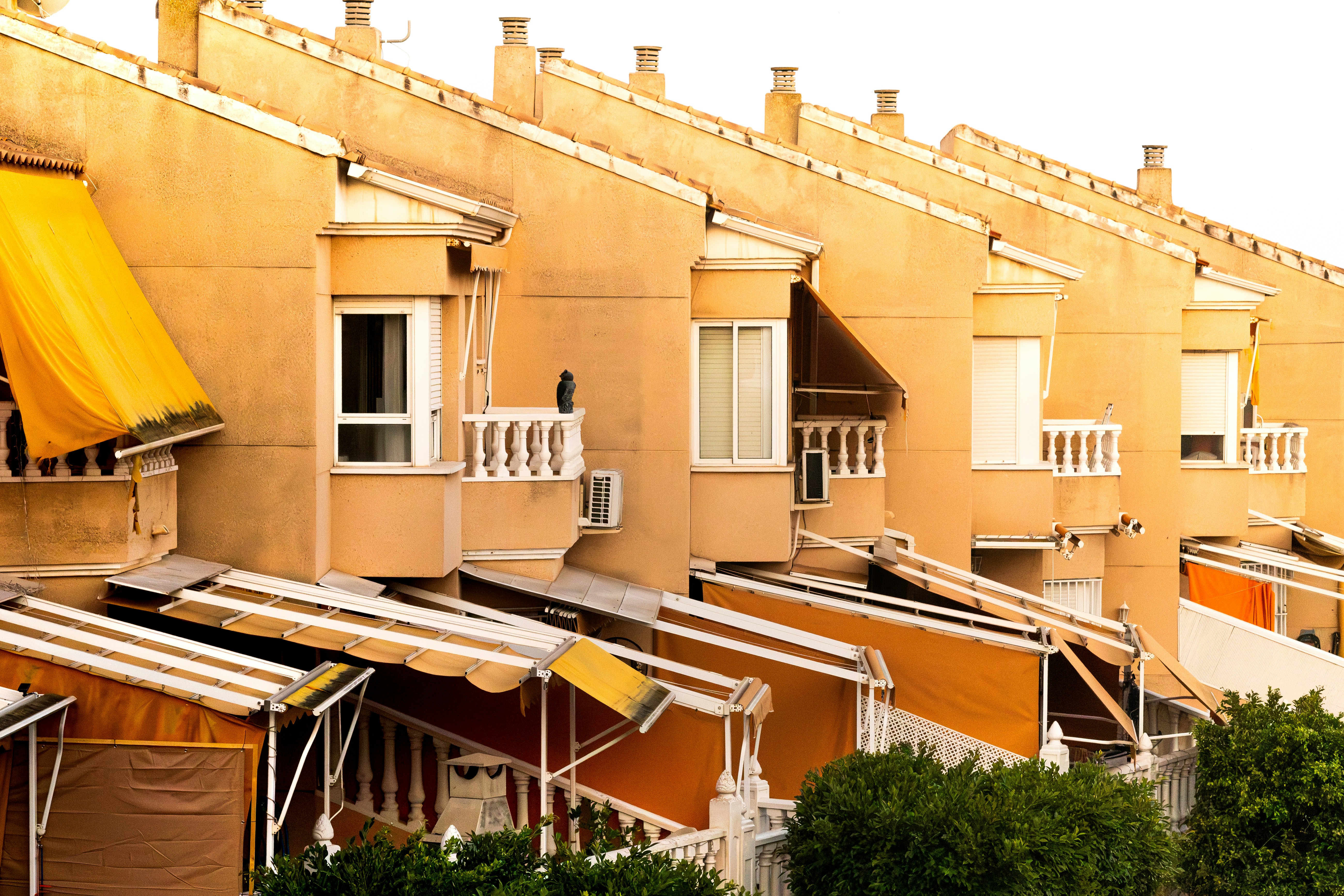 Sunlit Row: A Quiet Facade of Shade and Textile Canopies