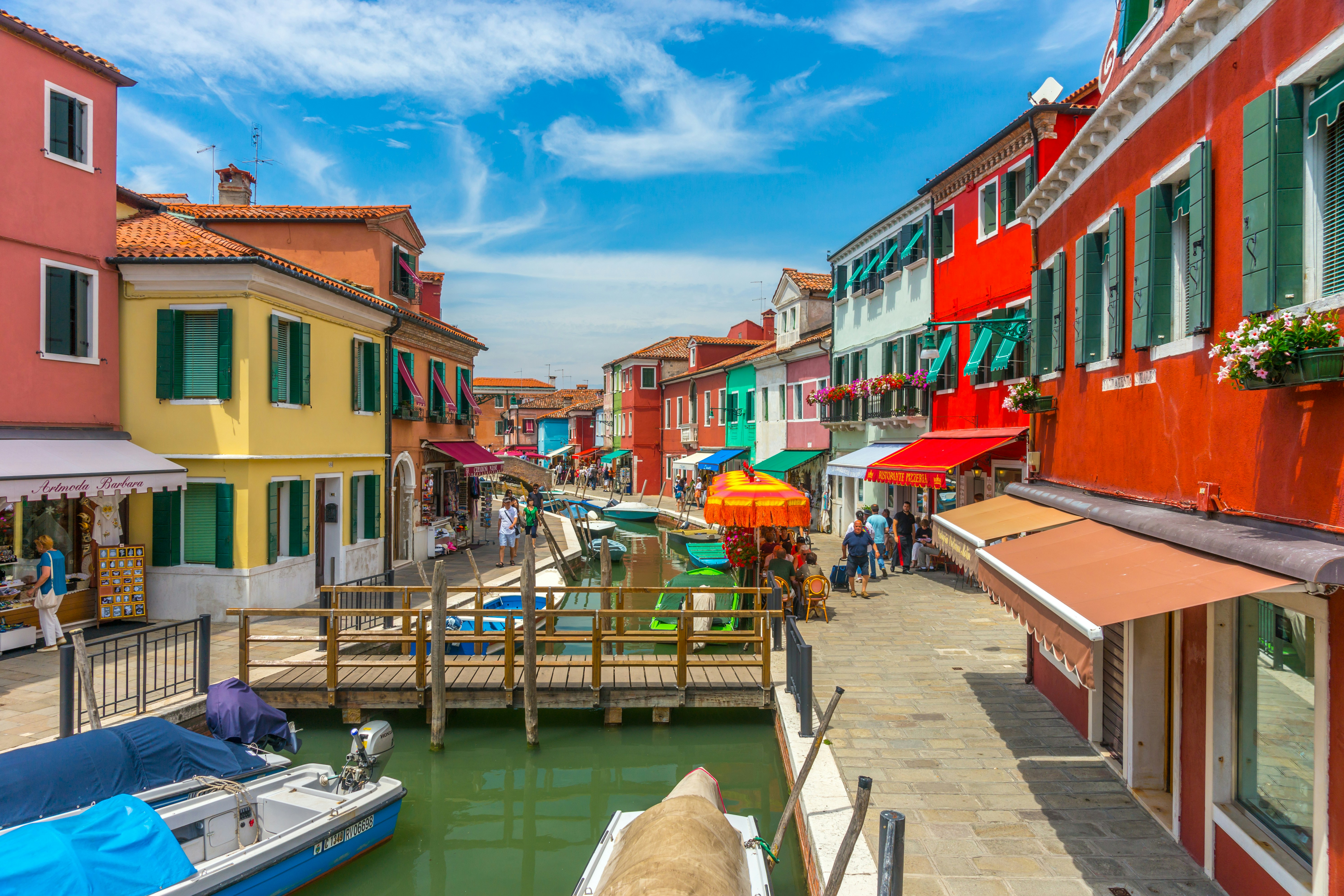 Colorful canal village under a bright Venetian-blue sky