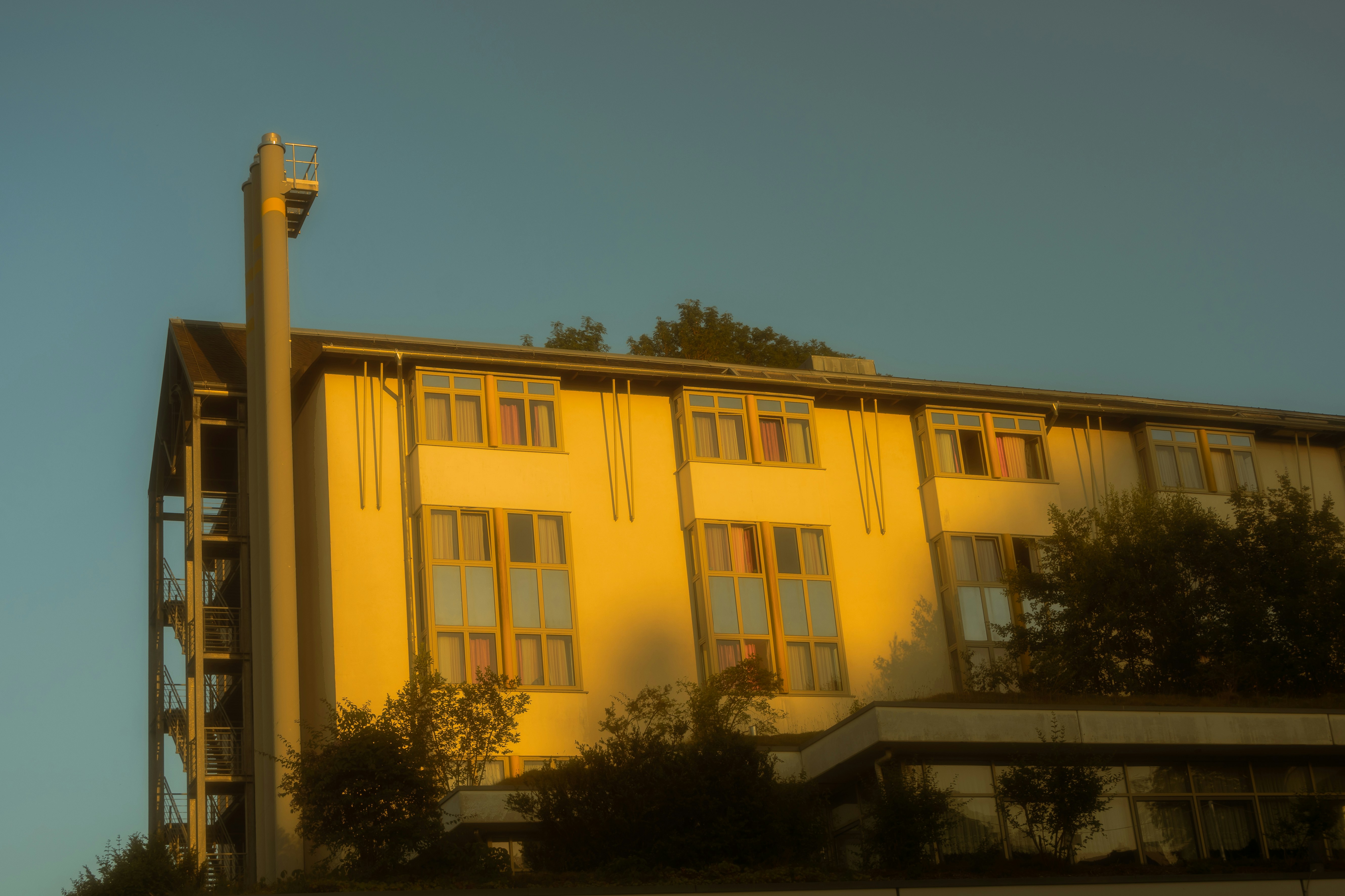 Sunlit Yellow Facade: Morning Light on a Mid-Century Campus Building