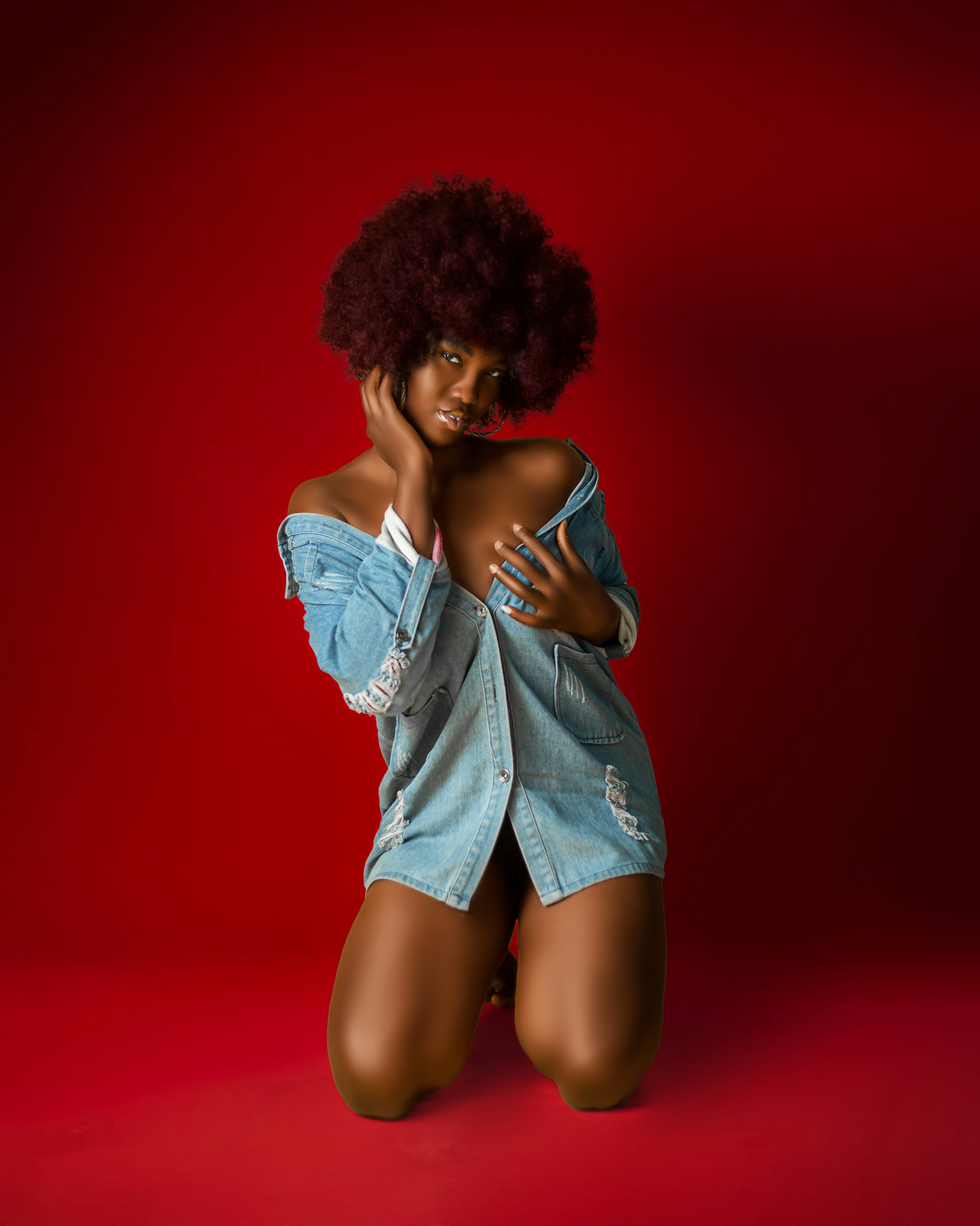 Crimson Backdrop, Denim Dreams: A Confident Portrait in Red