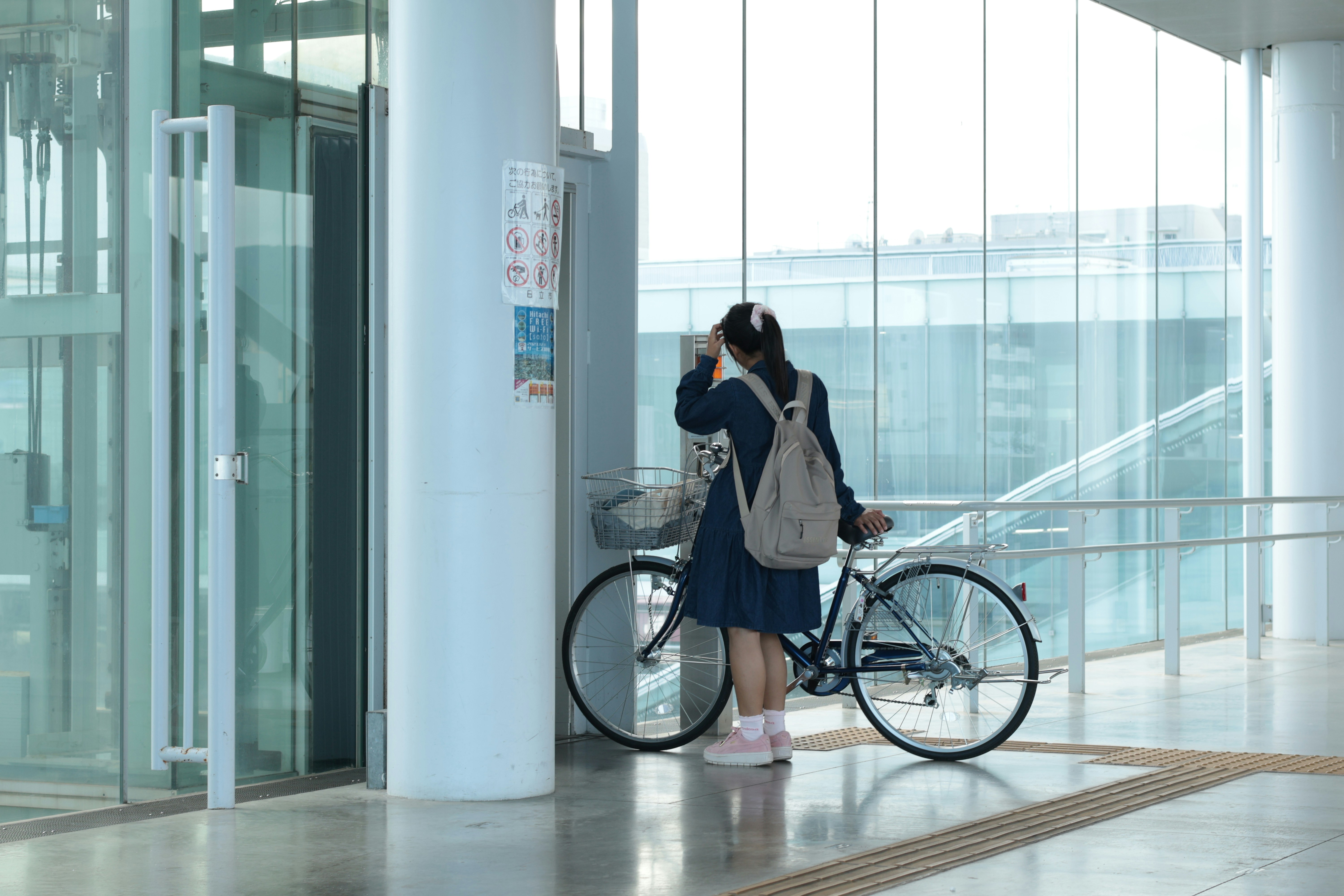 Girl with Bicycle at a Modern Glass Atrium