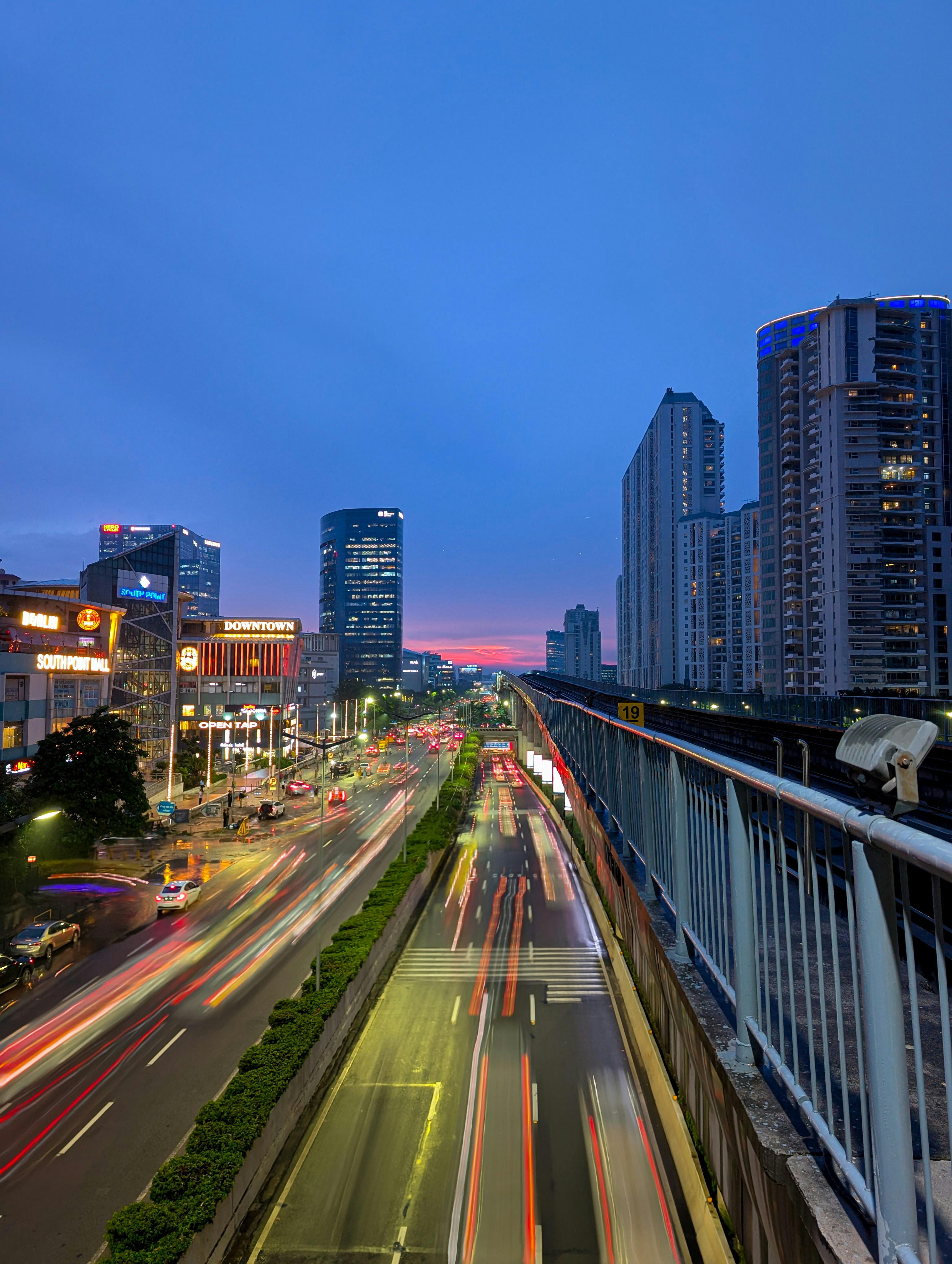 Urban Dawn Boulevard: A Neon-Streaked Skyline Over a Moving Street