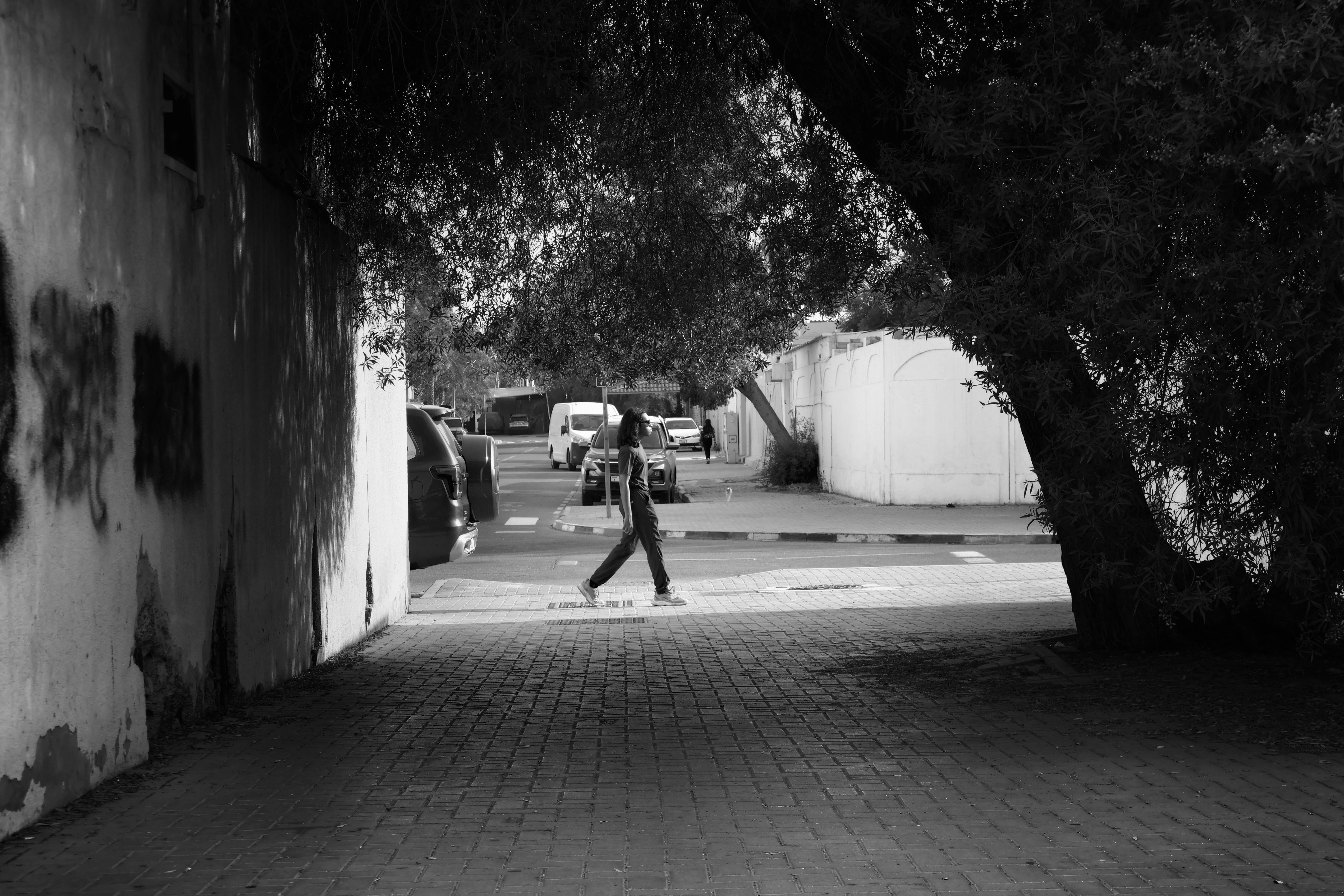 Pedestrian Crossing Under the Shadowed Archway