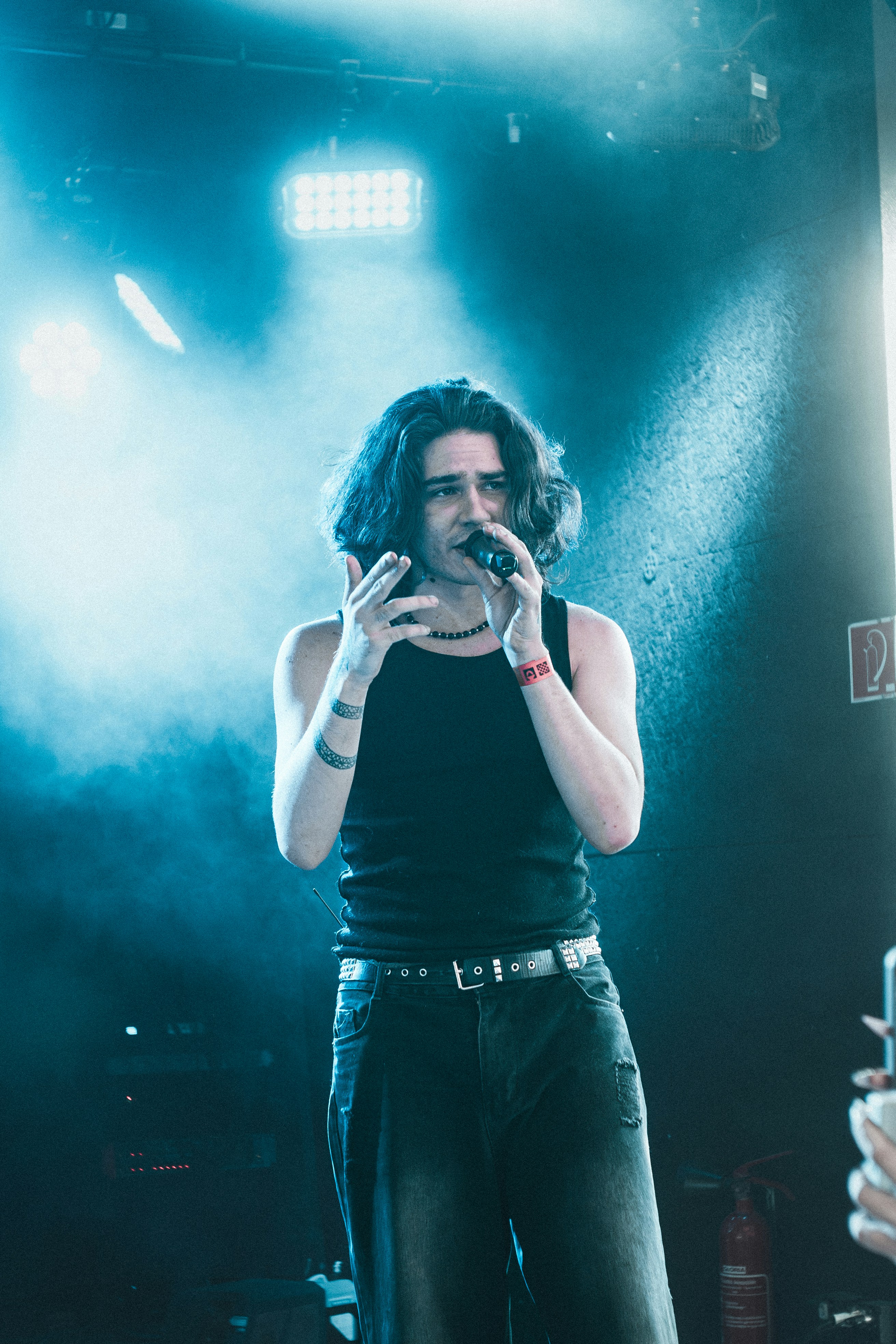 Vocal Fire: A Rock Performer in Blue Mist Under Stage Lights