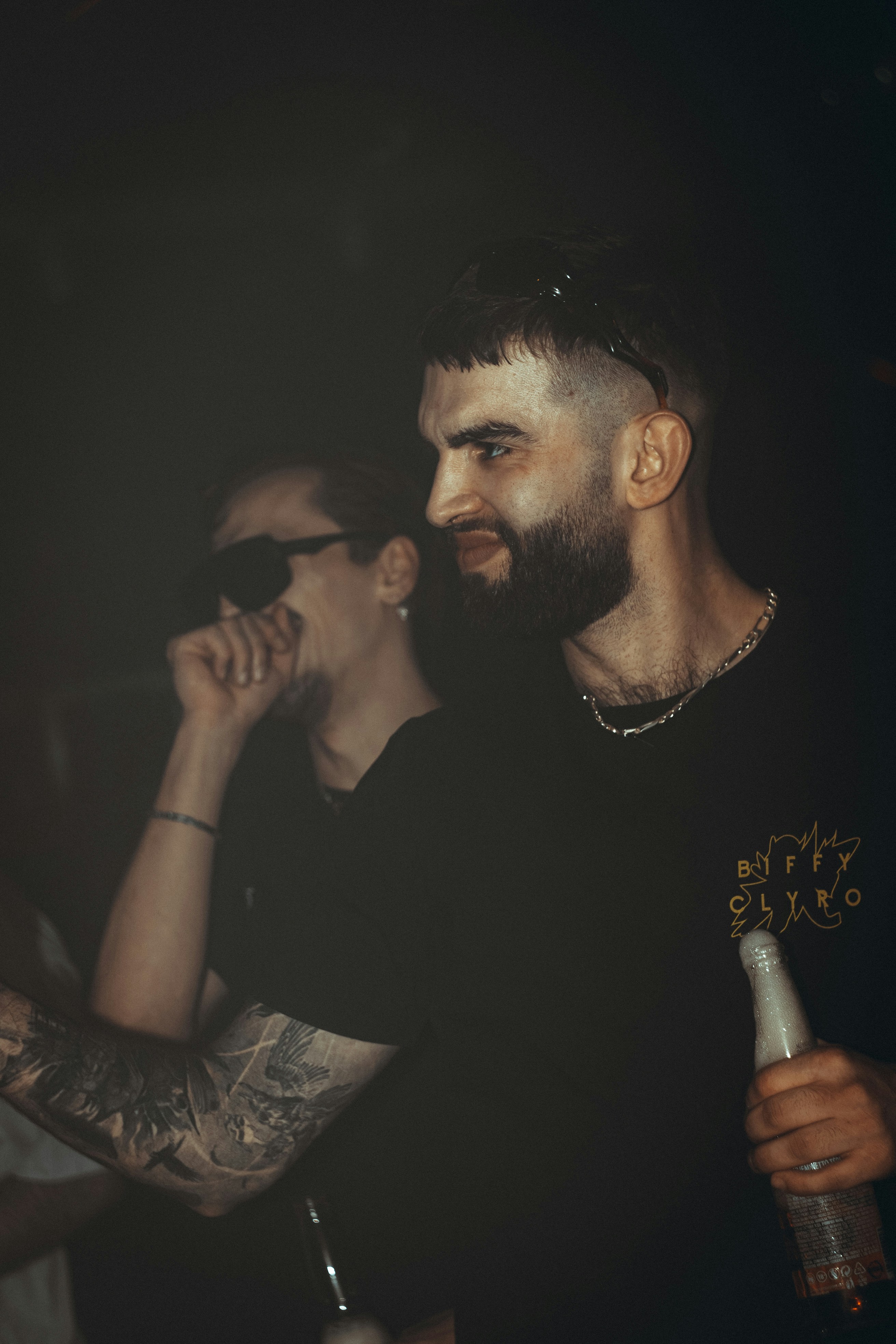 Bearded confidant in the glow of a club light