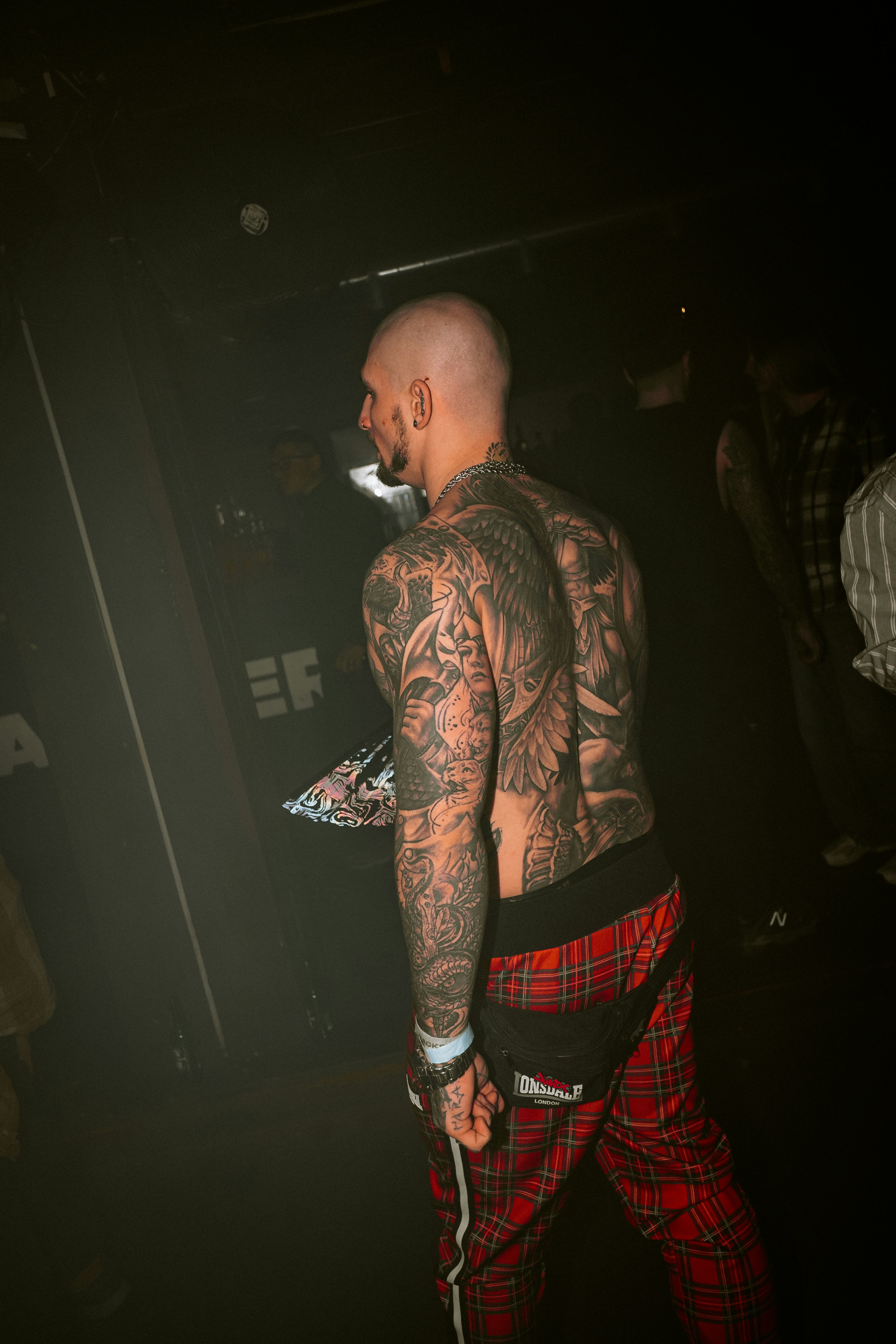 Tattooed silhouette in a moody club glow