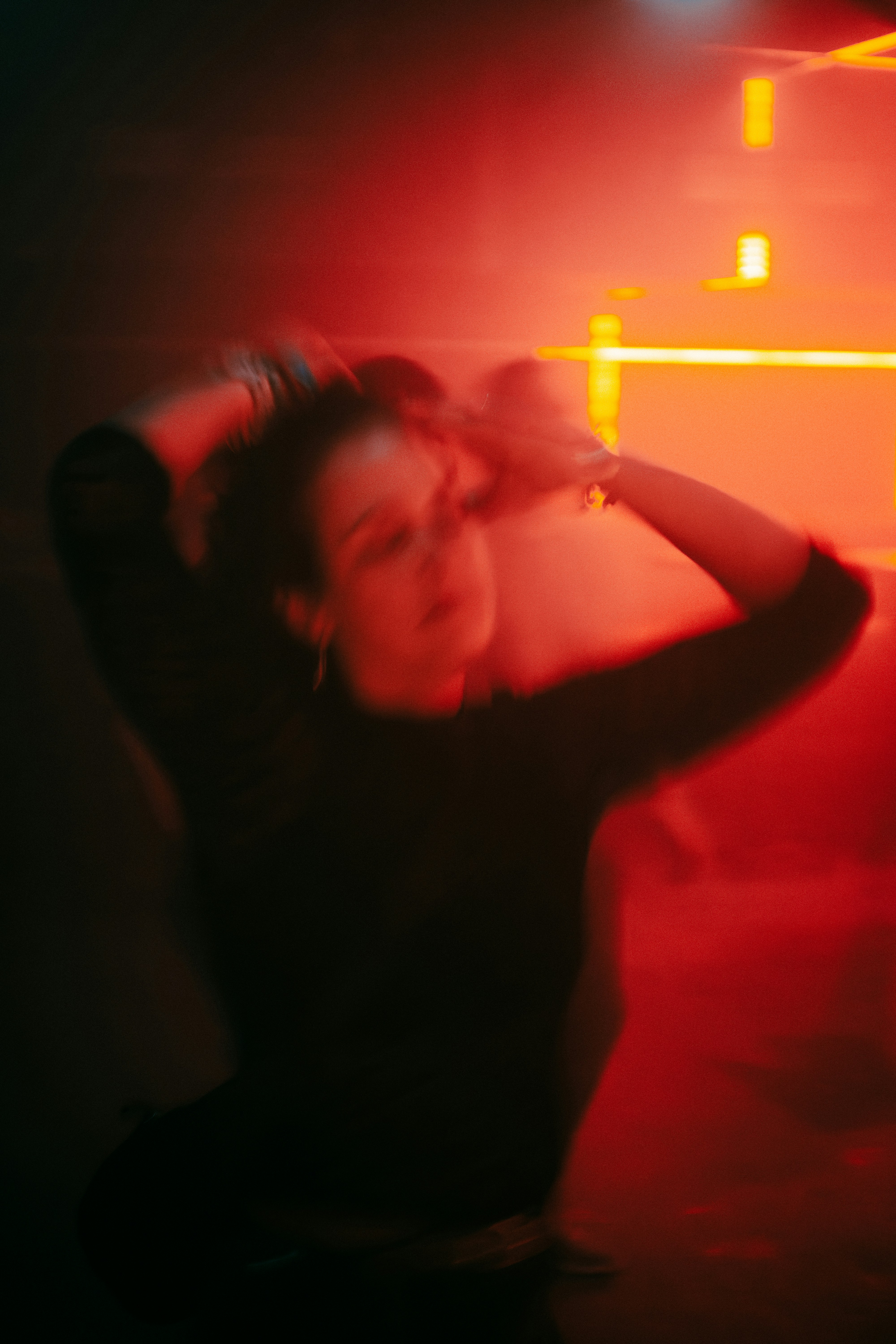 Neon Red Motion: A Blurred Figure Dances in the Glow