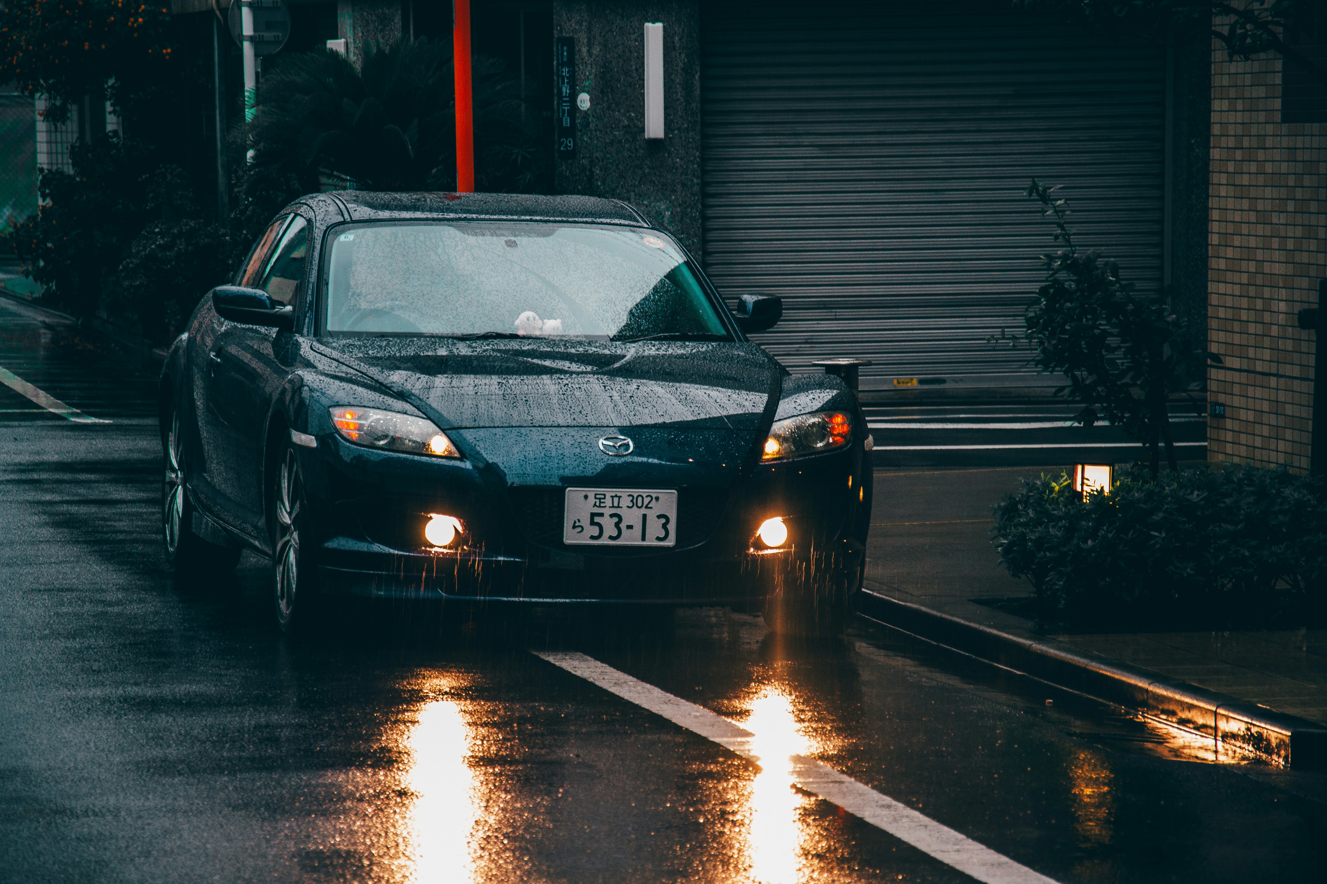 Rainy Street Spectacle: A Nissan Streaking Through Neon Reflections