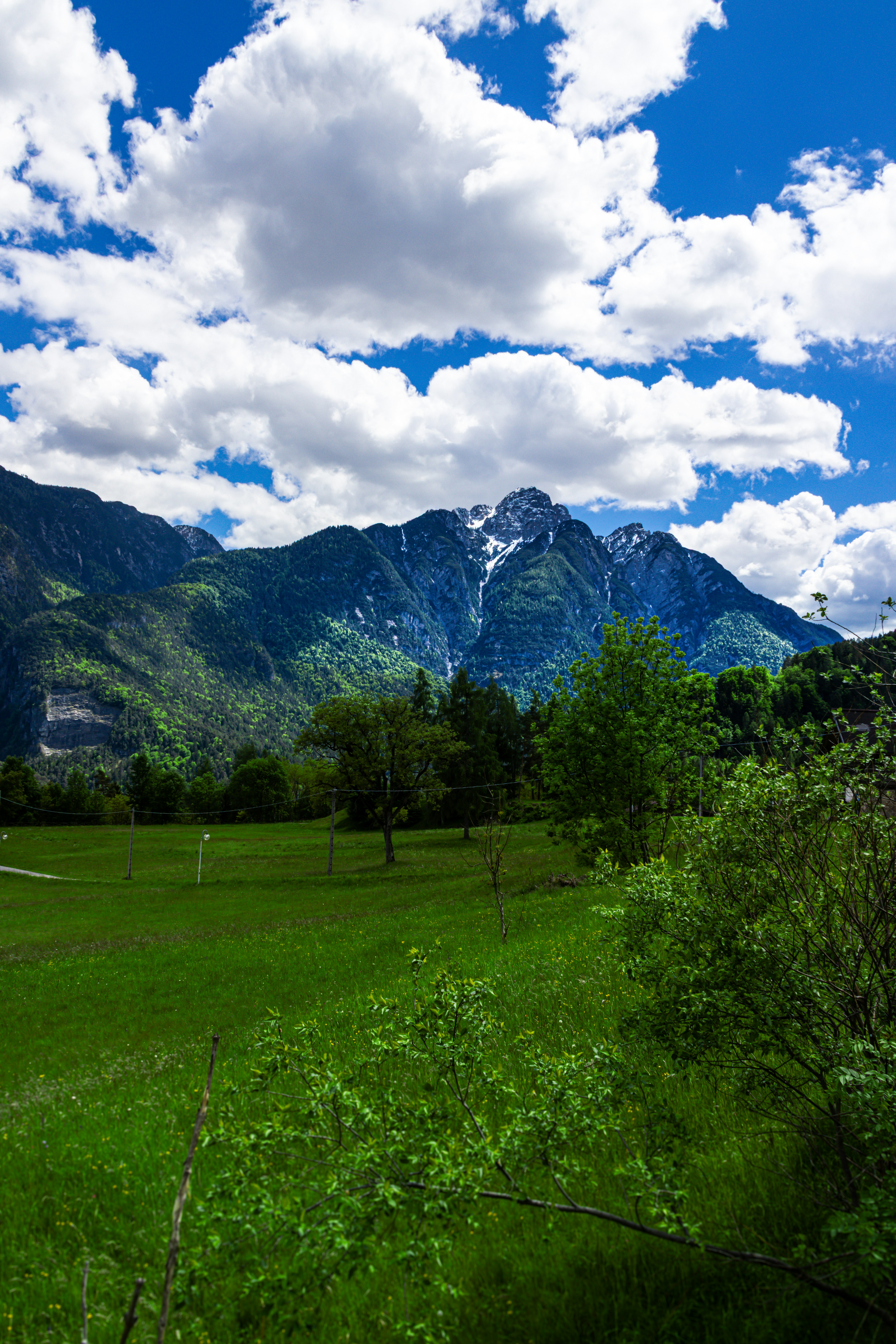 Azure Sky over Green Valley: Mountain Range Beneath Fluffy Clouds