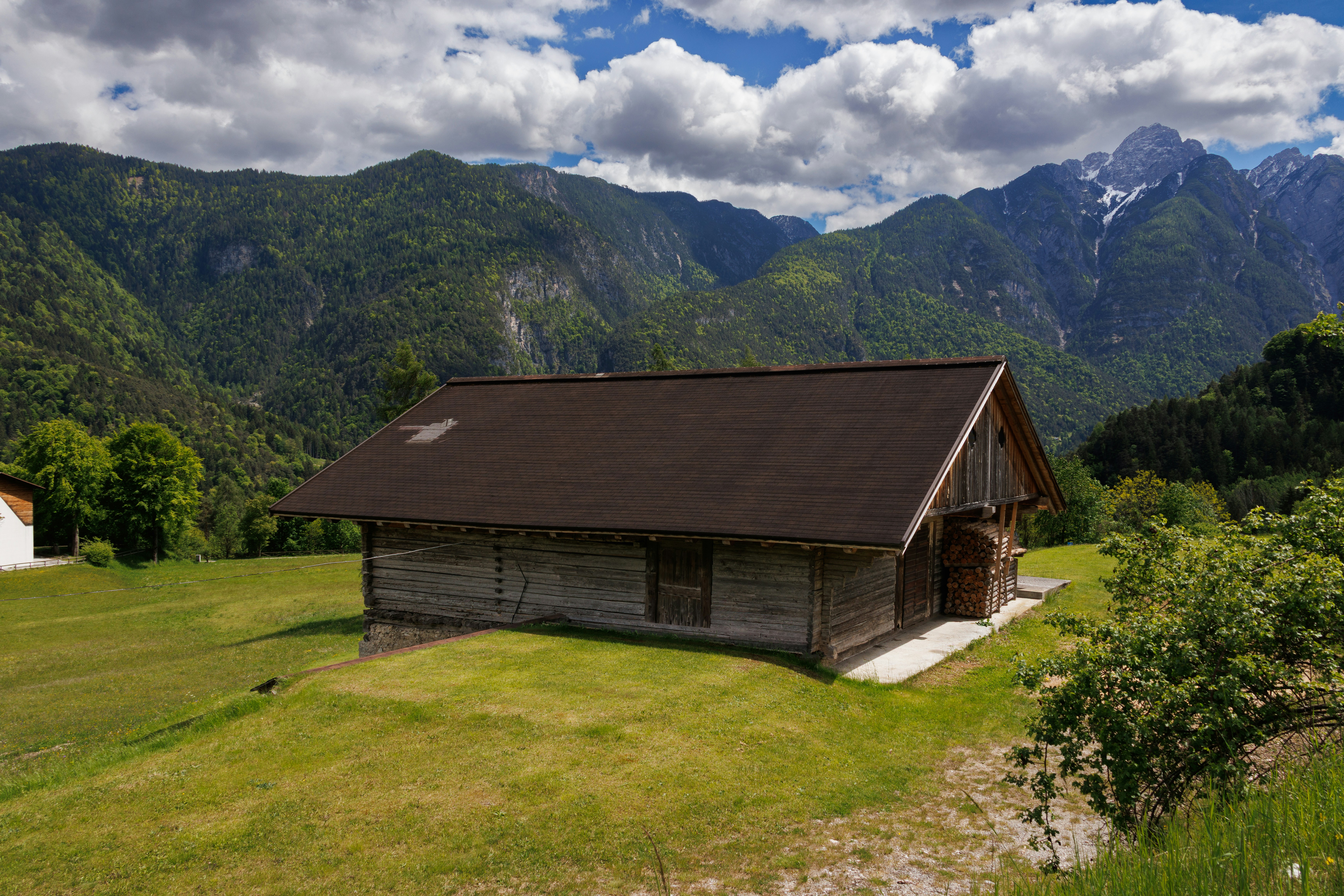 Alpine Cabin in the Meadow under a Snow-dusted Crest