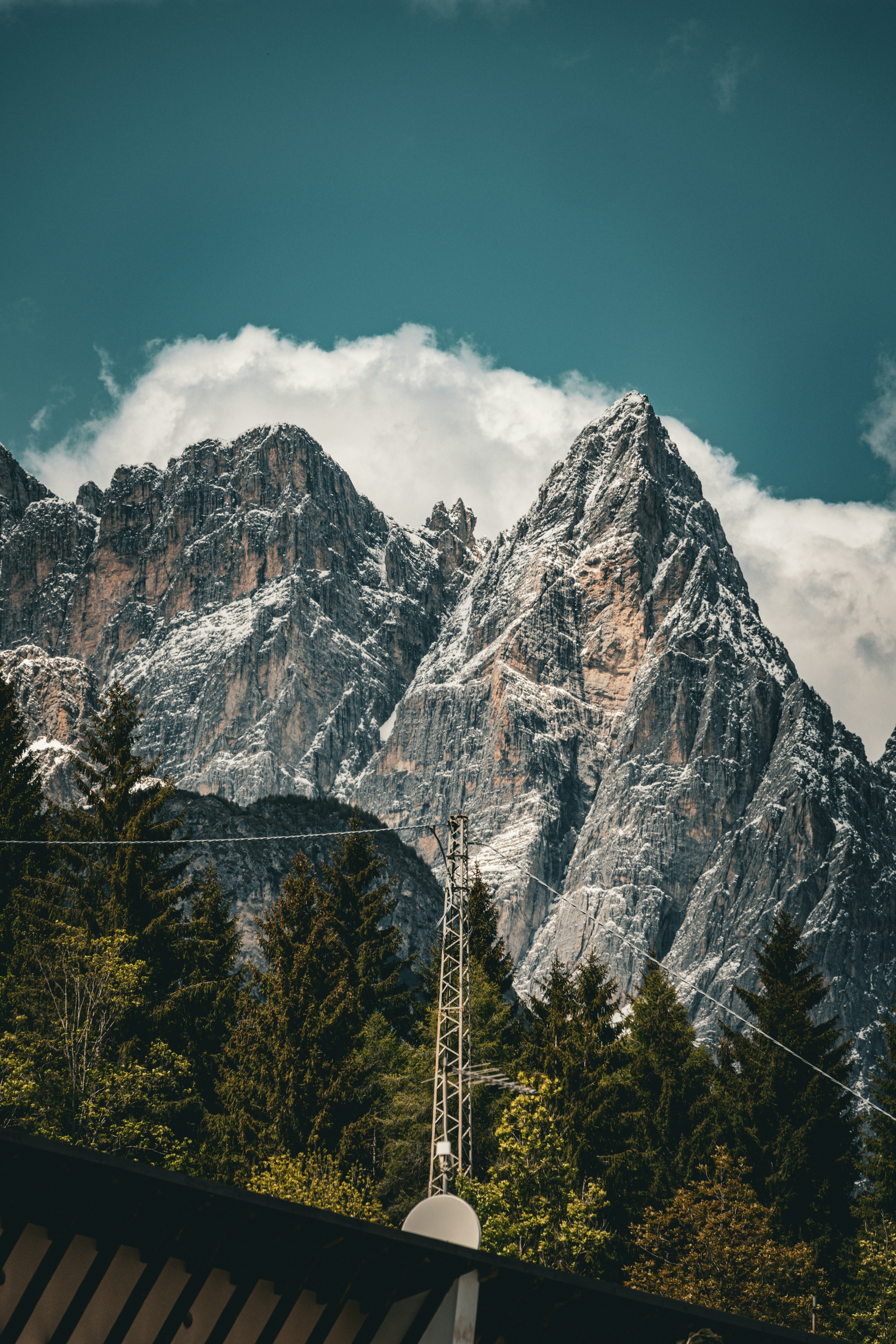 Snow-capped Peaks Rising Behind a Forest Bench and Antenna