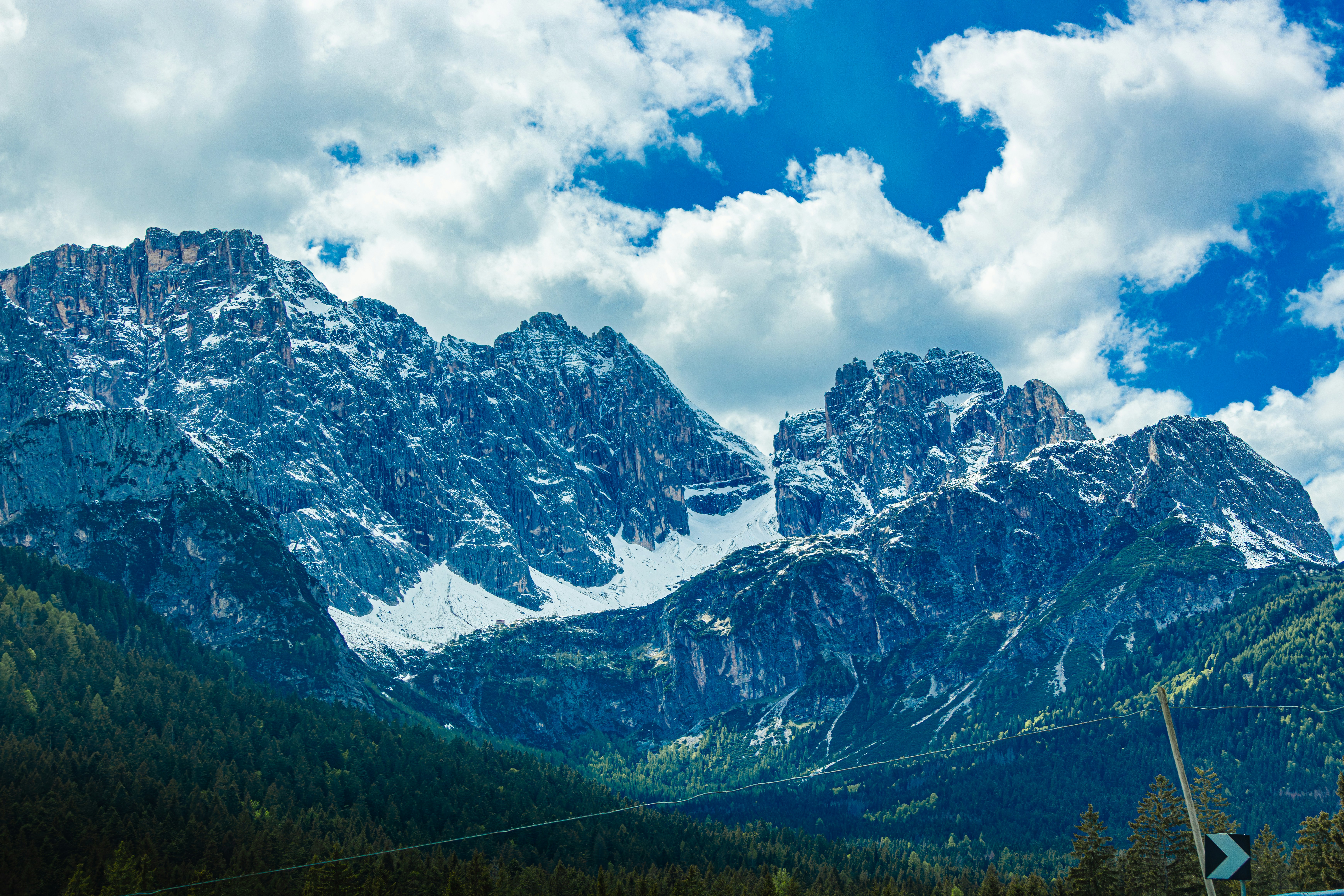 Snow-kissed Peaks Under a Sky of Cotton Clouds
