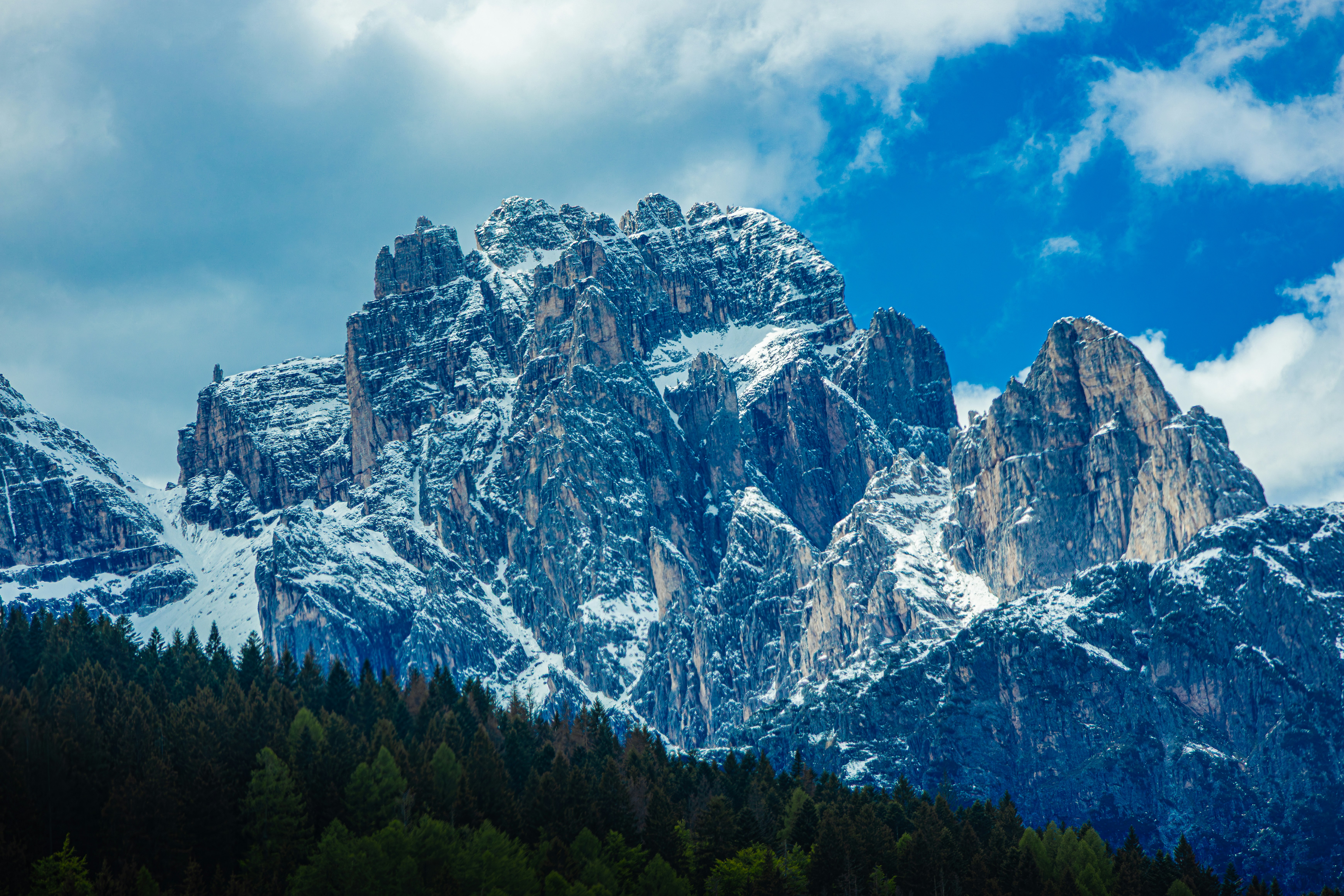 Snowbound Giants: A Peak Crowned by Clouds and Pine