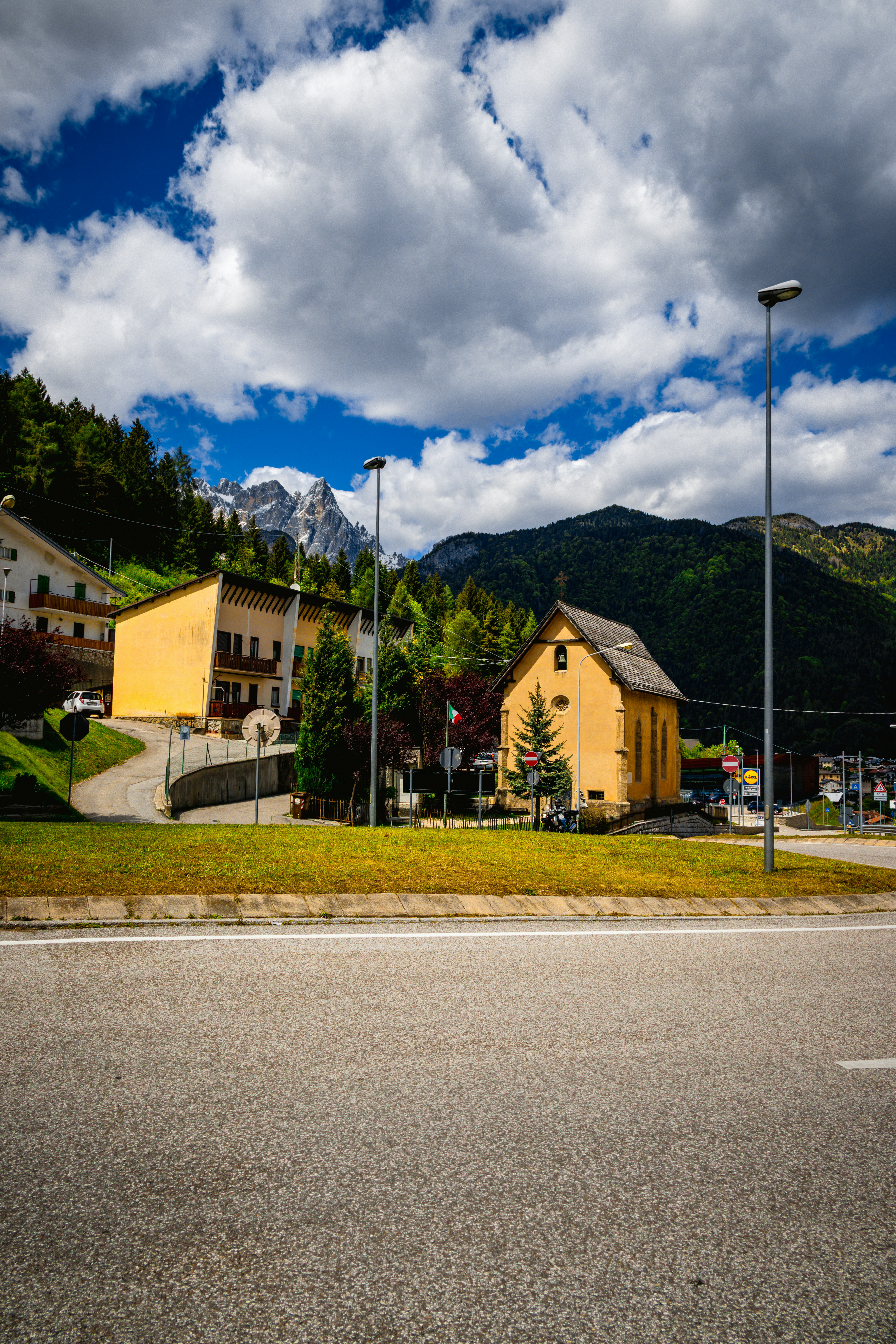 Sunny alpine village with yellow houses under a blue sky
