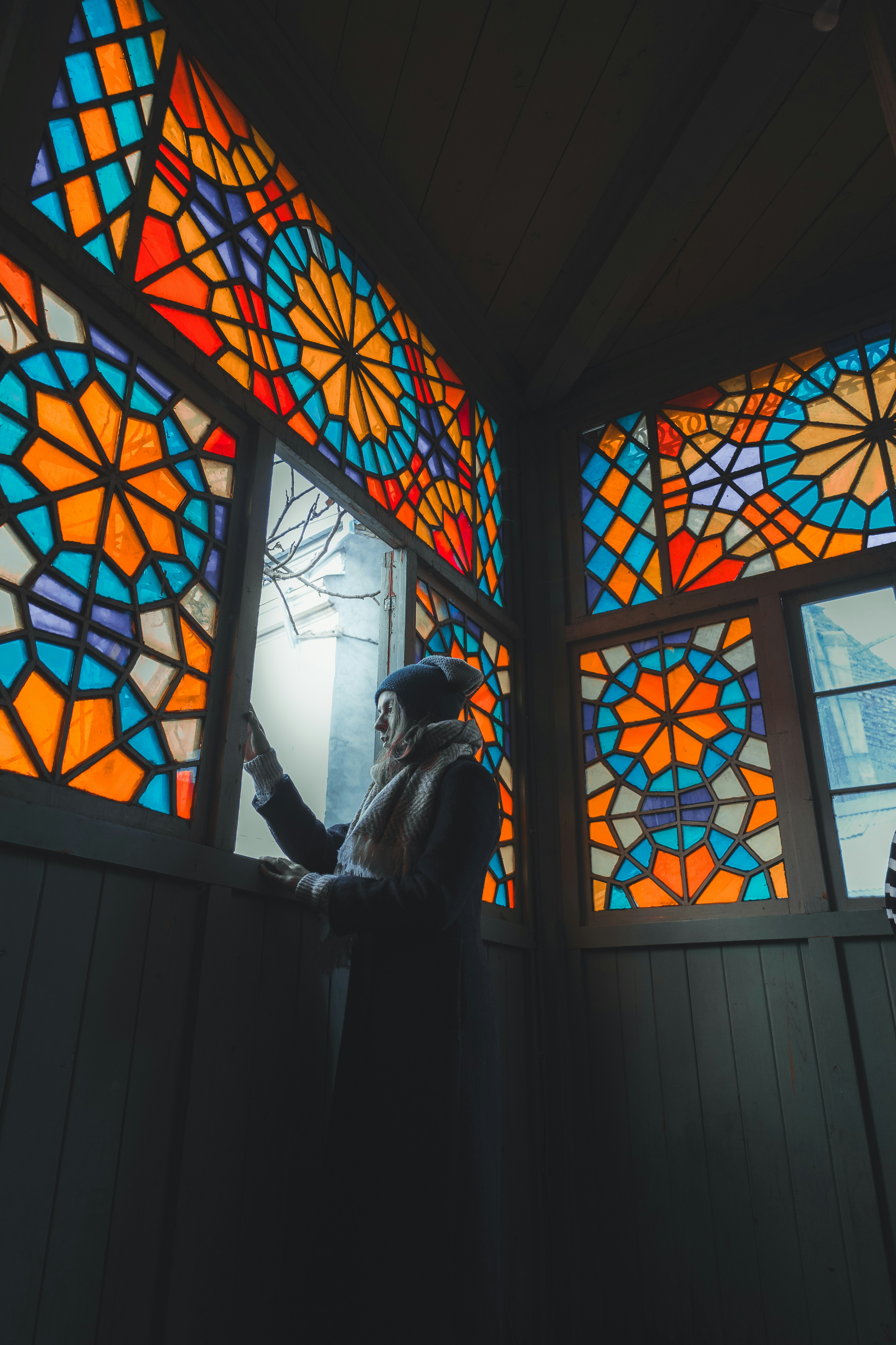 Stained Glass Reverie: A Figure Silhouetted by Kaleidoscopic Windows